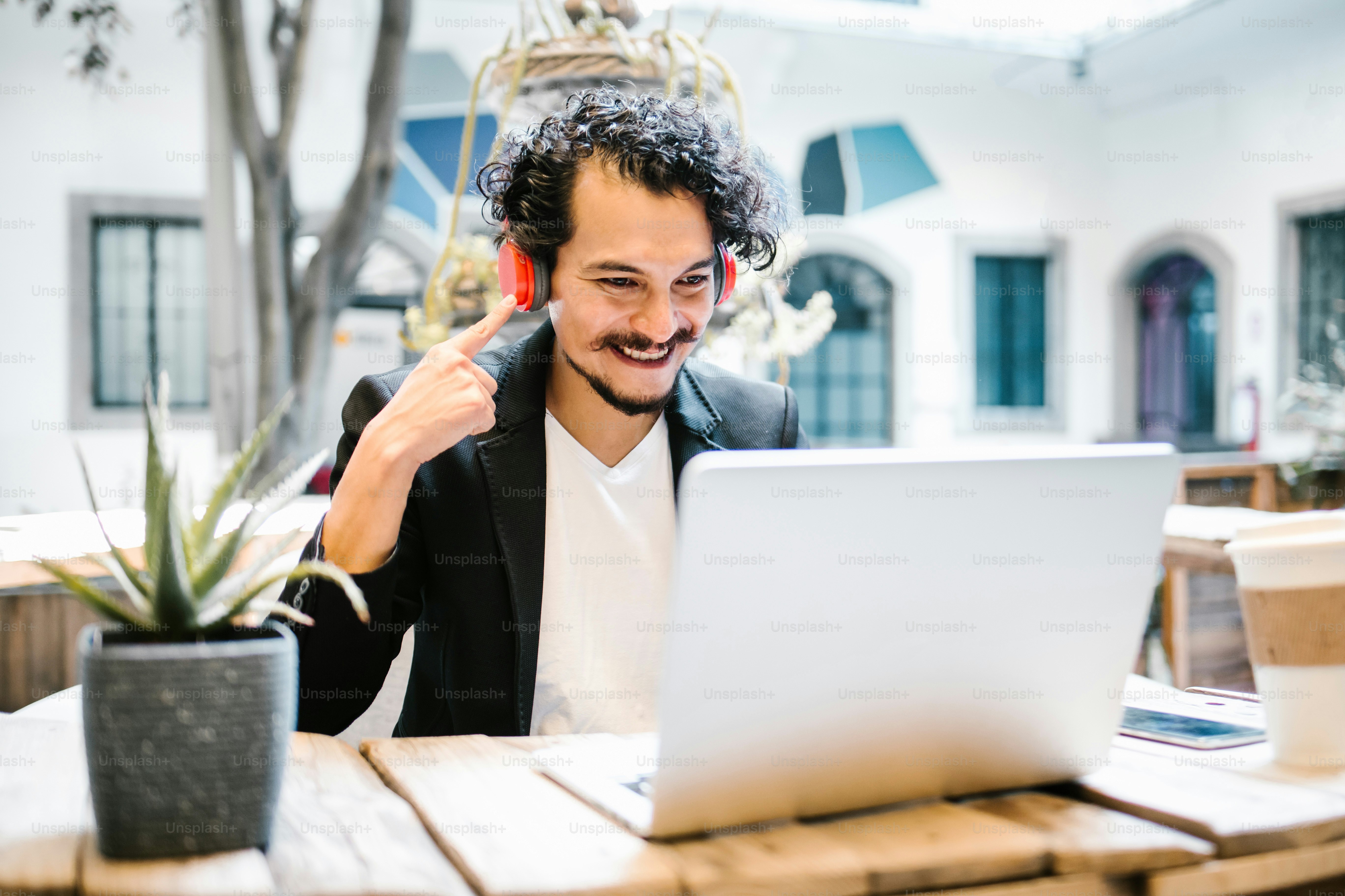 Latin man working with computer in a video conference call with ...