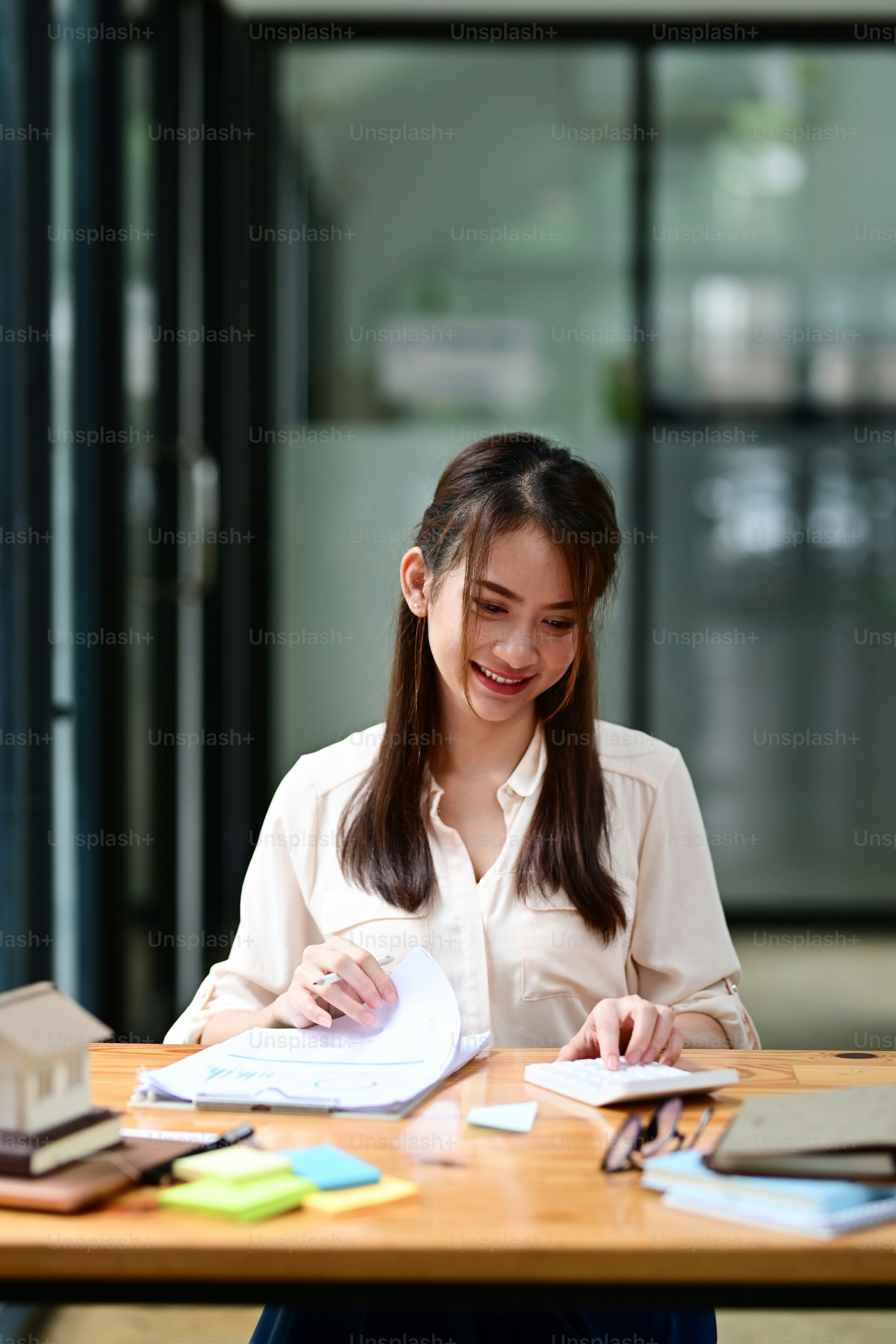 Happy young woman accountant checking financial reports at office ...