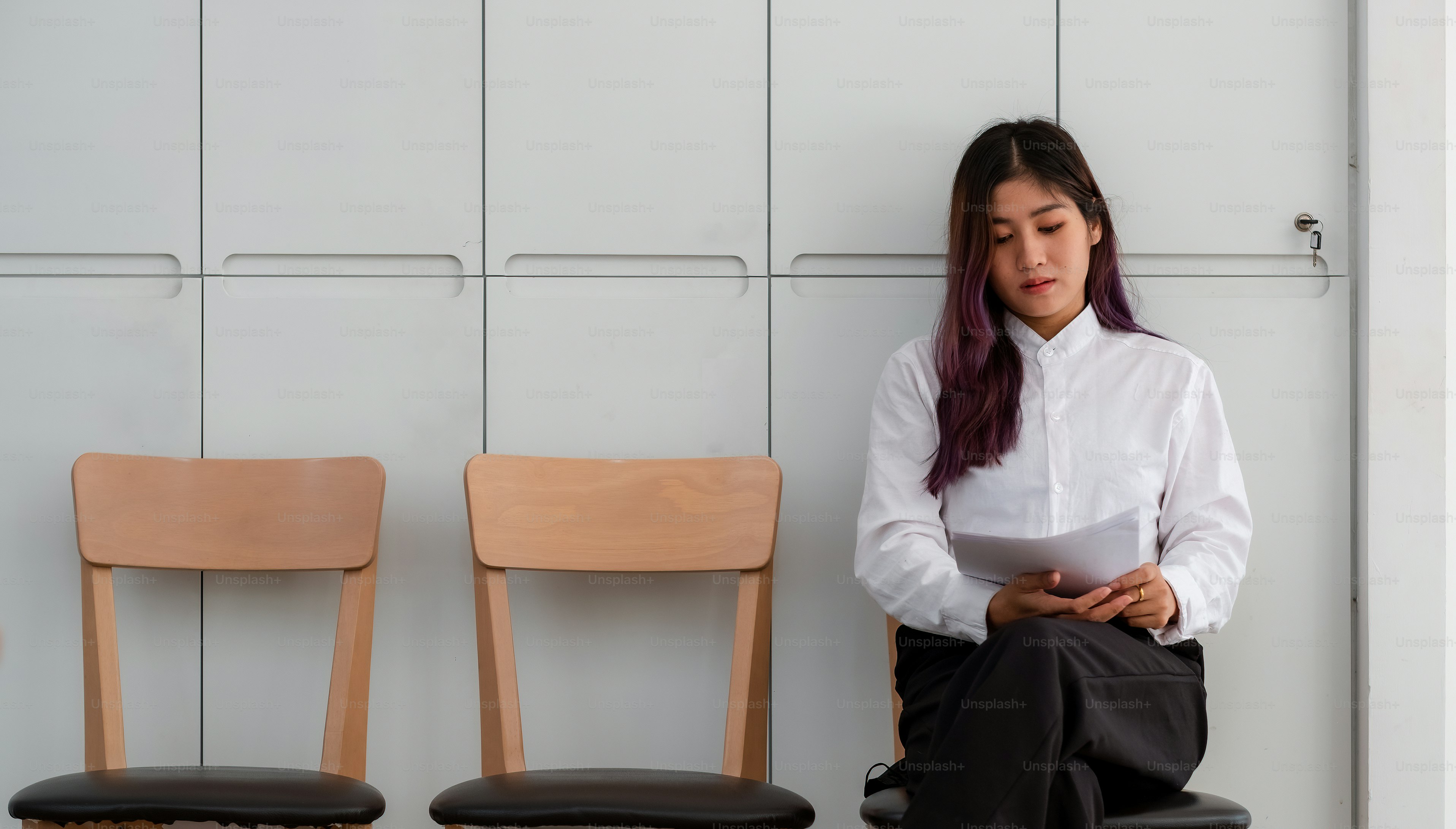 Asian woman with resume sitting to review the documents while waiting for a job interview. photo ...