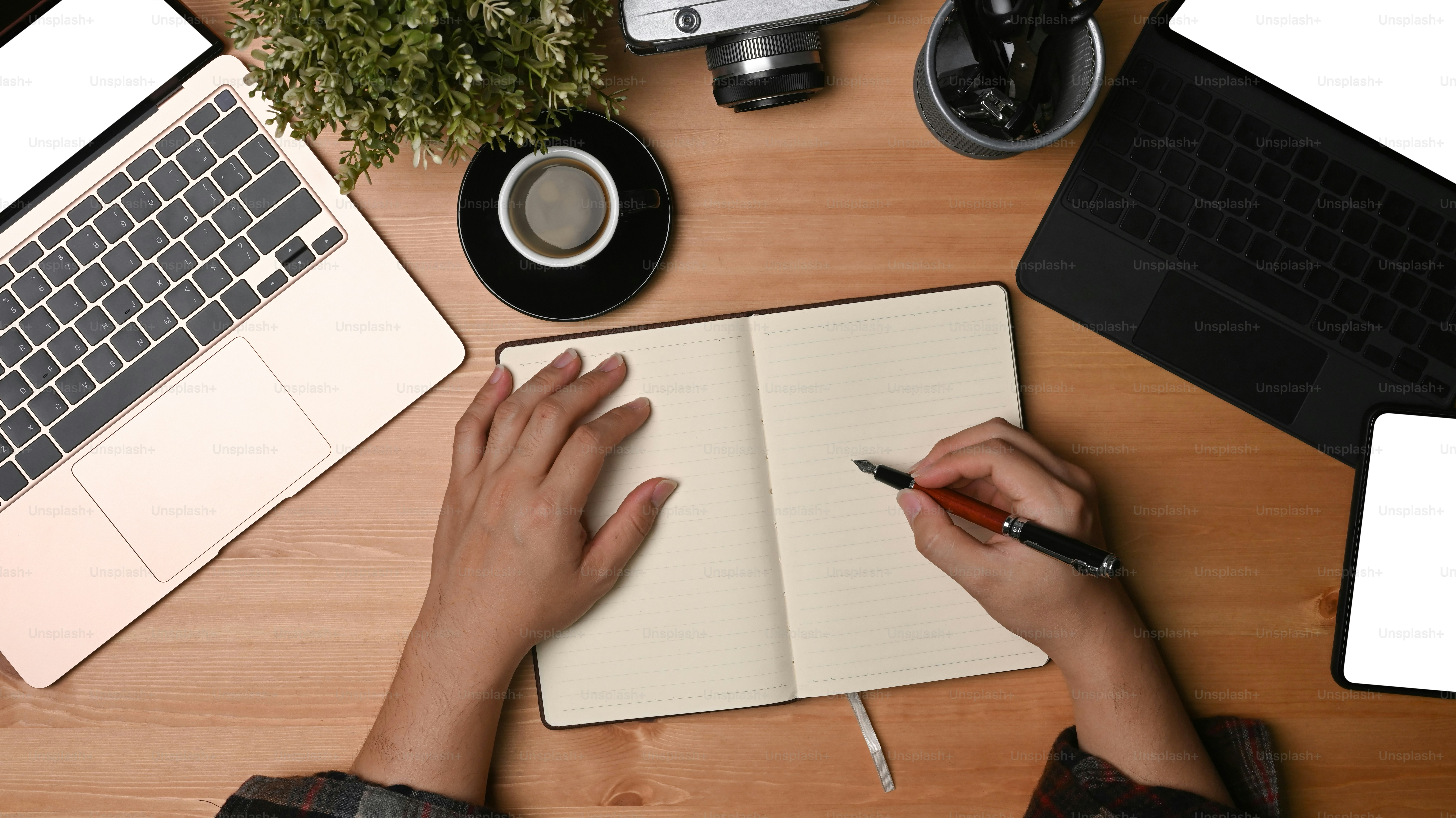 Man photographer writing something on notebook at his workspace. photo ...