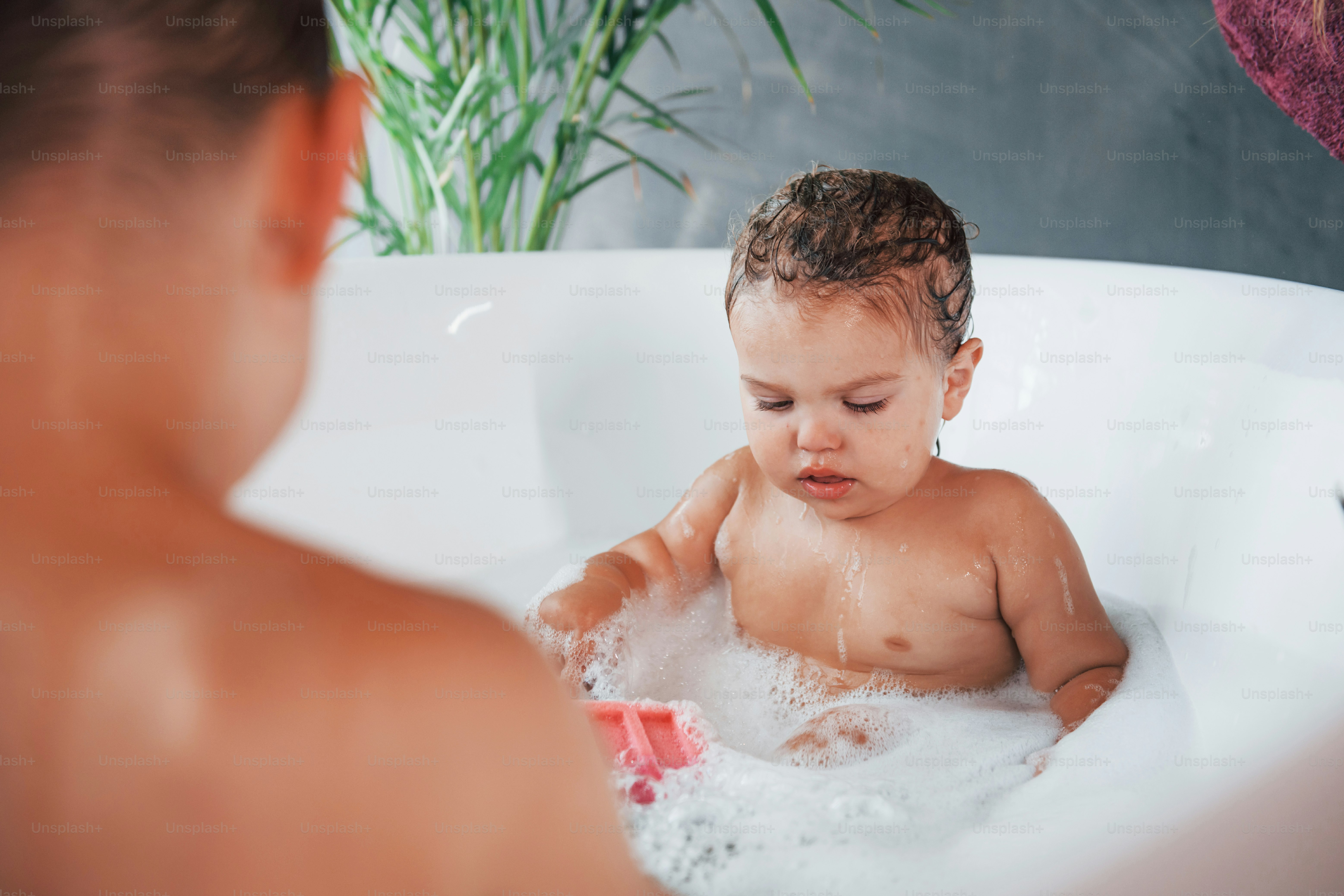 Two kids having fun and washing themselves in the bath at home. photo – Baby Image on Unsplash