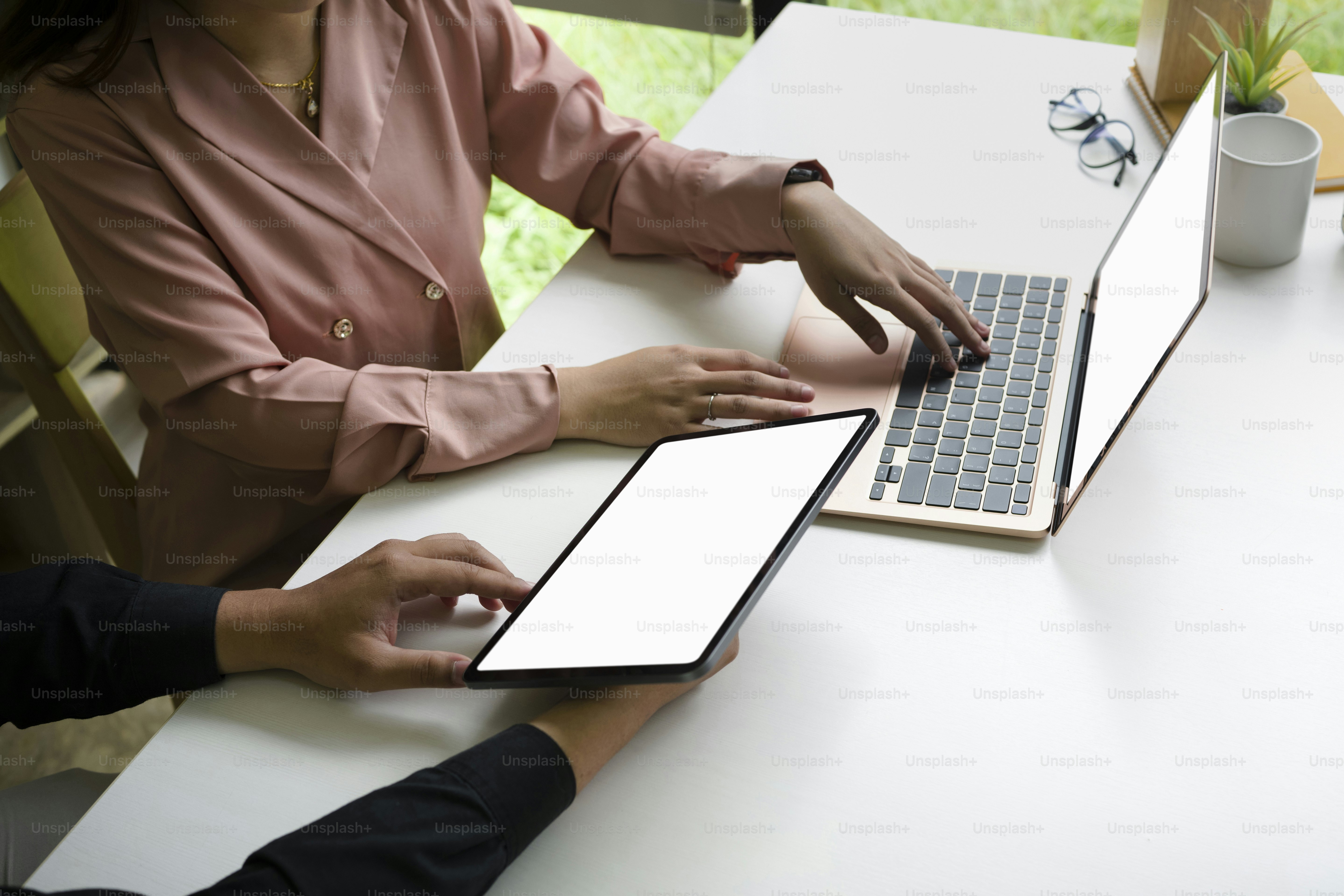 Two business colleagues working with modern devices in office. photo ...