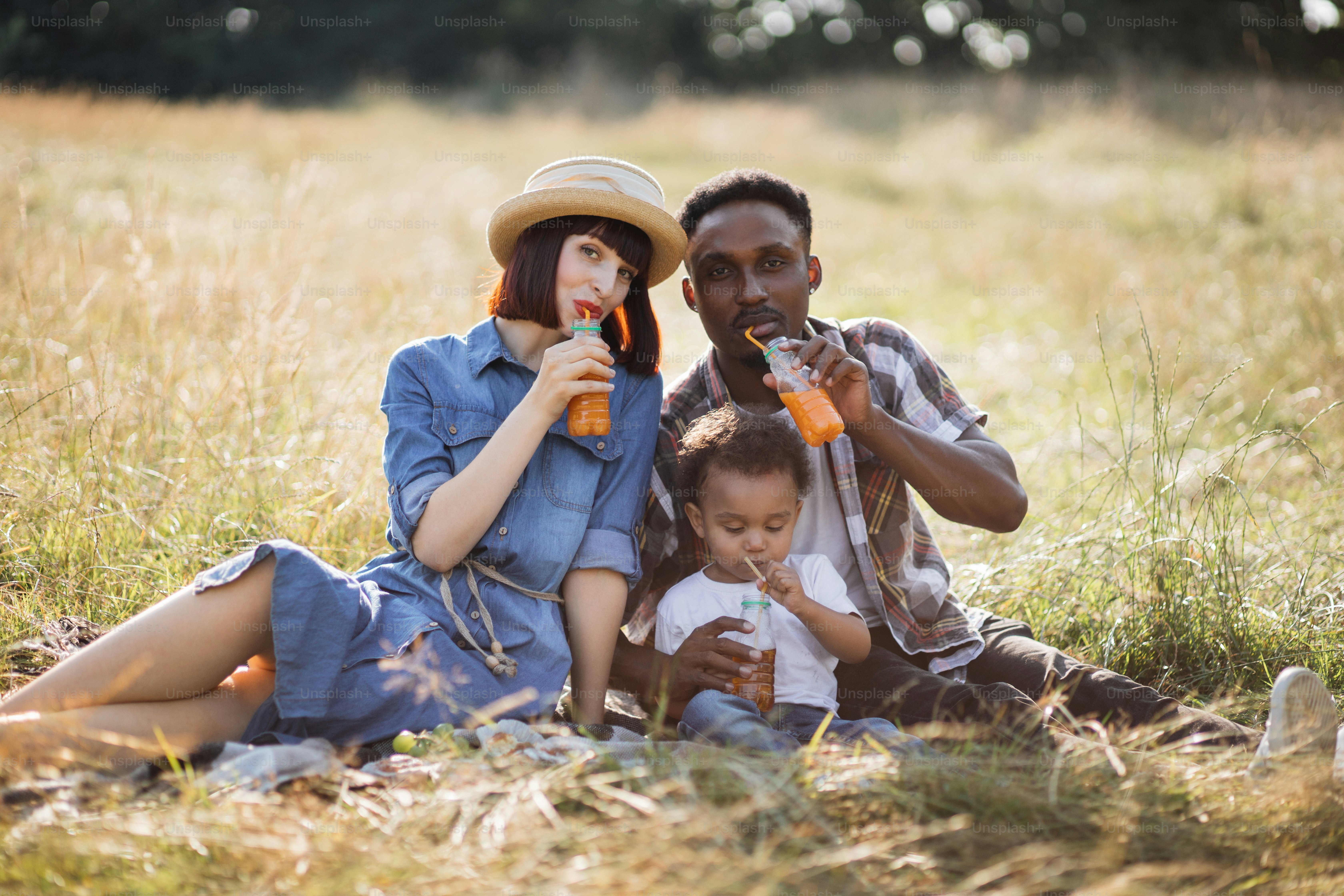 Portrait of happy multi ethnic parents embracing little cute son while ...