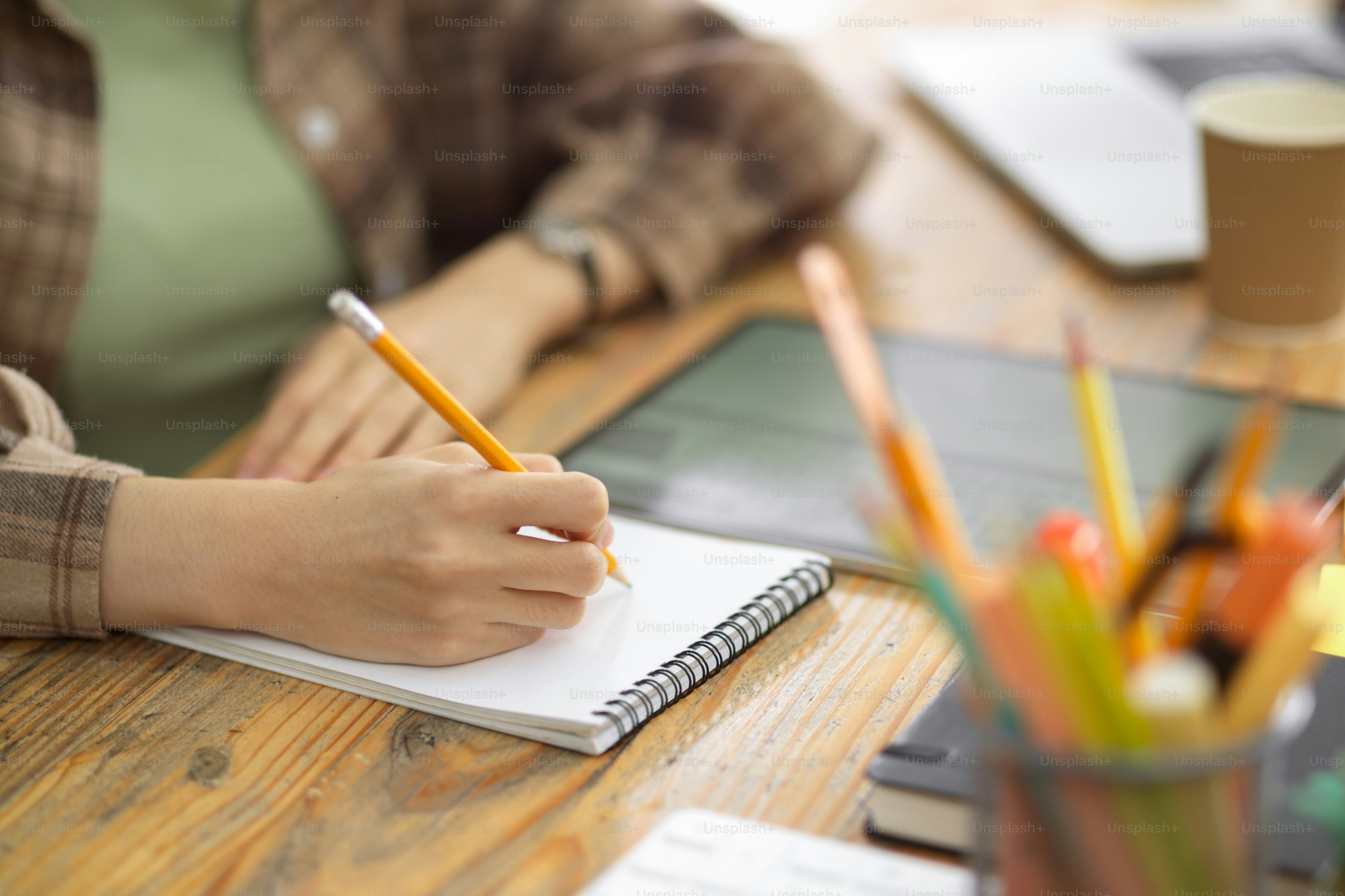 Closeup, young hipster female college taking note, do homework on ...