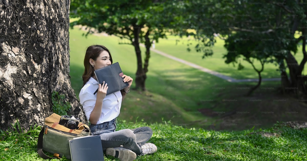 공원의 나무 아래에 앉아 재미있는 책을 읽는 평화로운 젊은 여성 사진 Unsplash의 네이처 Nature 예약 이미지
