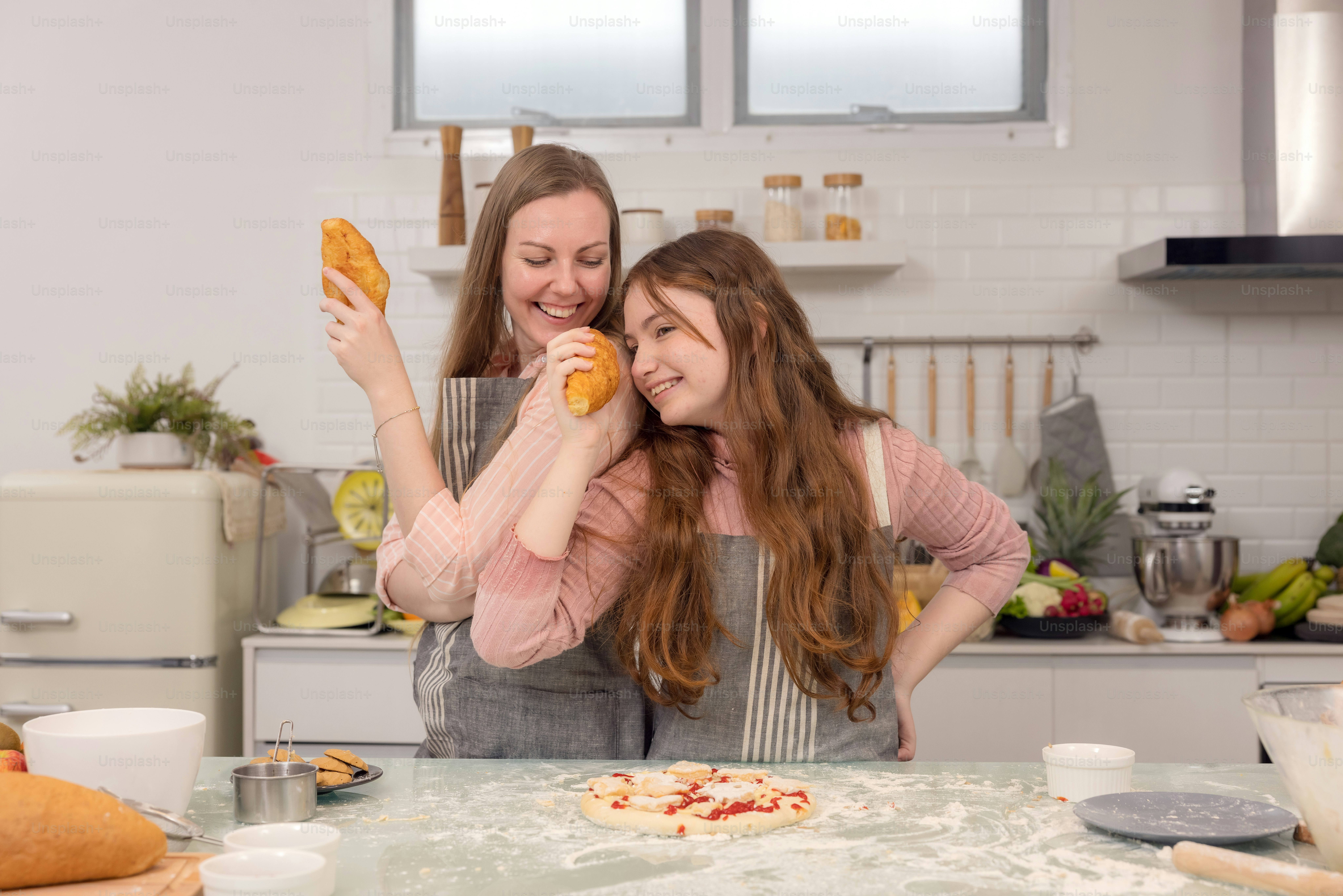 Mother and daughters use bread to sing and entertain one other. photo ...