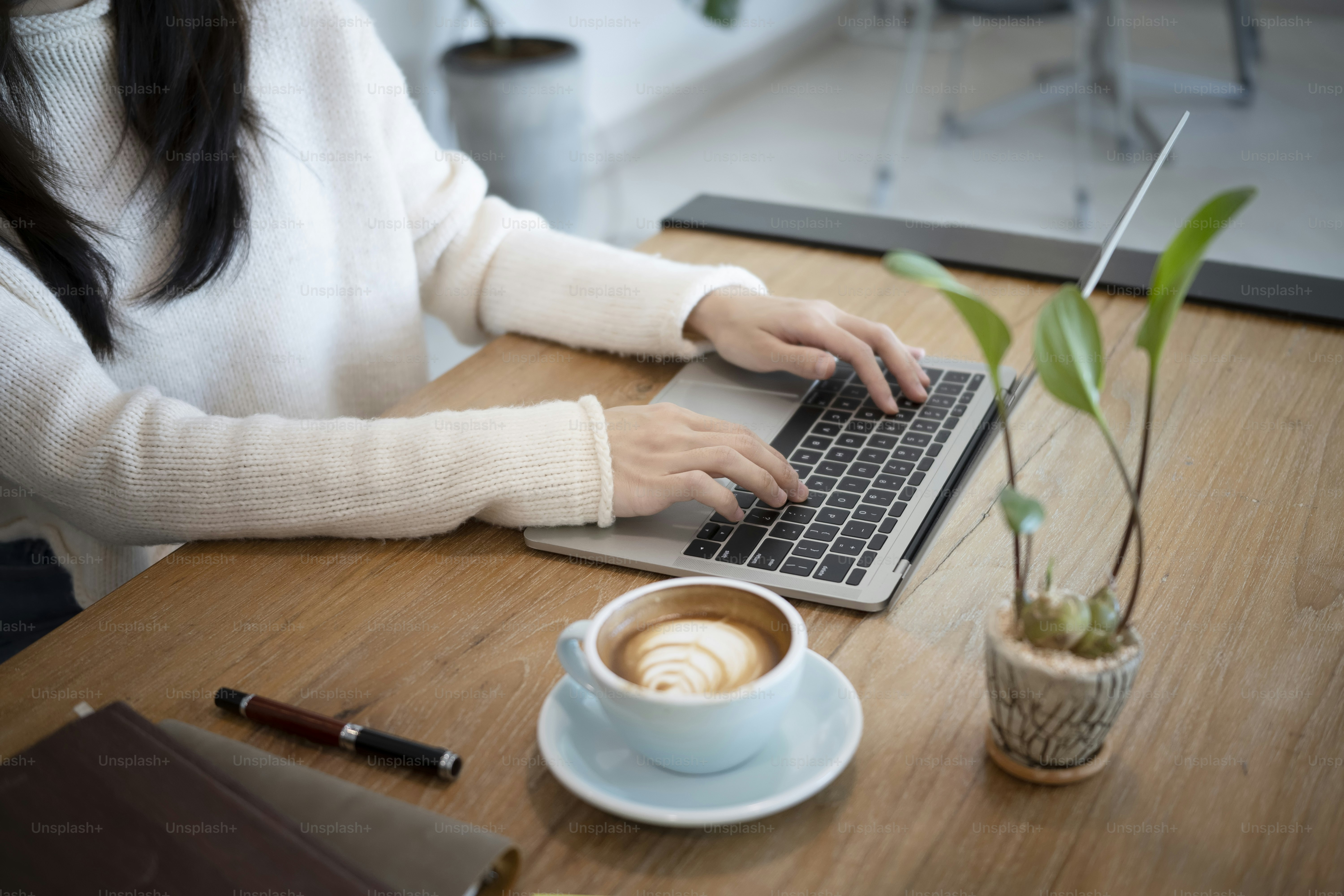 Cropped shot young female in white sweater working with computer laptop ...