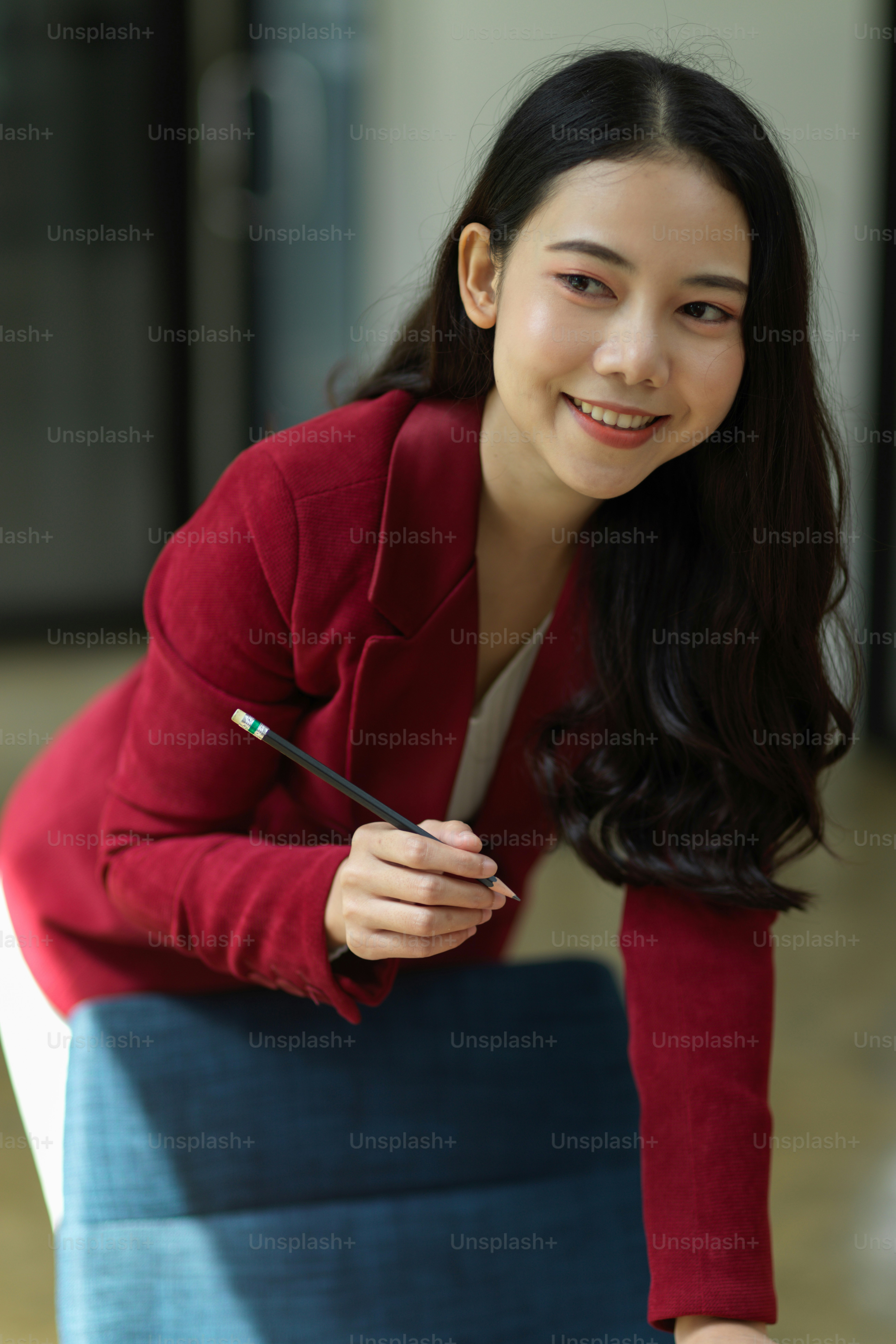 Portrait of Pretty young smart businesswoman in red suit leaning on ...