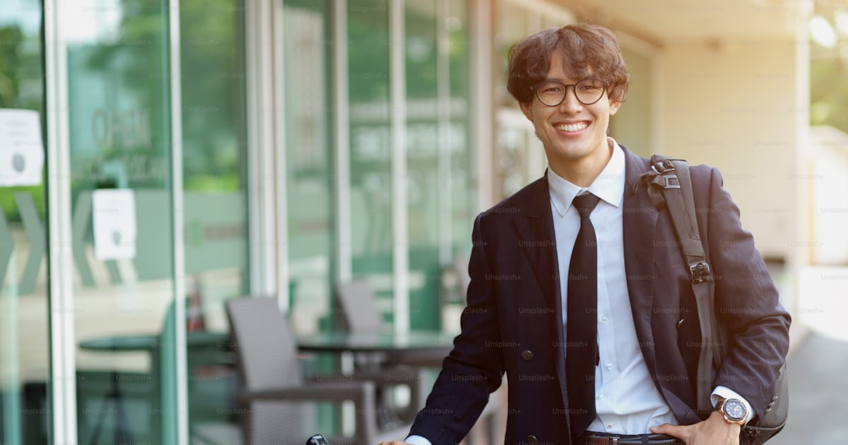 자신감 넘치는 잘 생긴 아시아 젊은 사업가가 자전거로 일하고 현대적인 거리에서 자전거를 타고 야외를 걷고 있다 사진