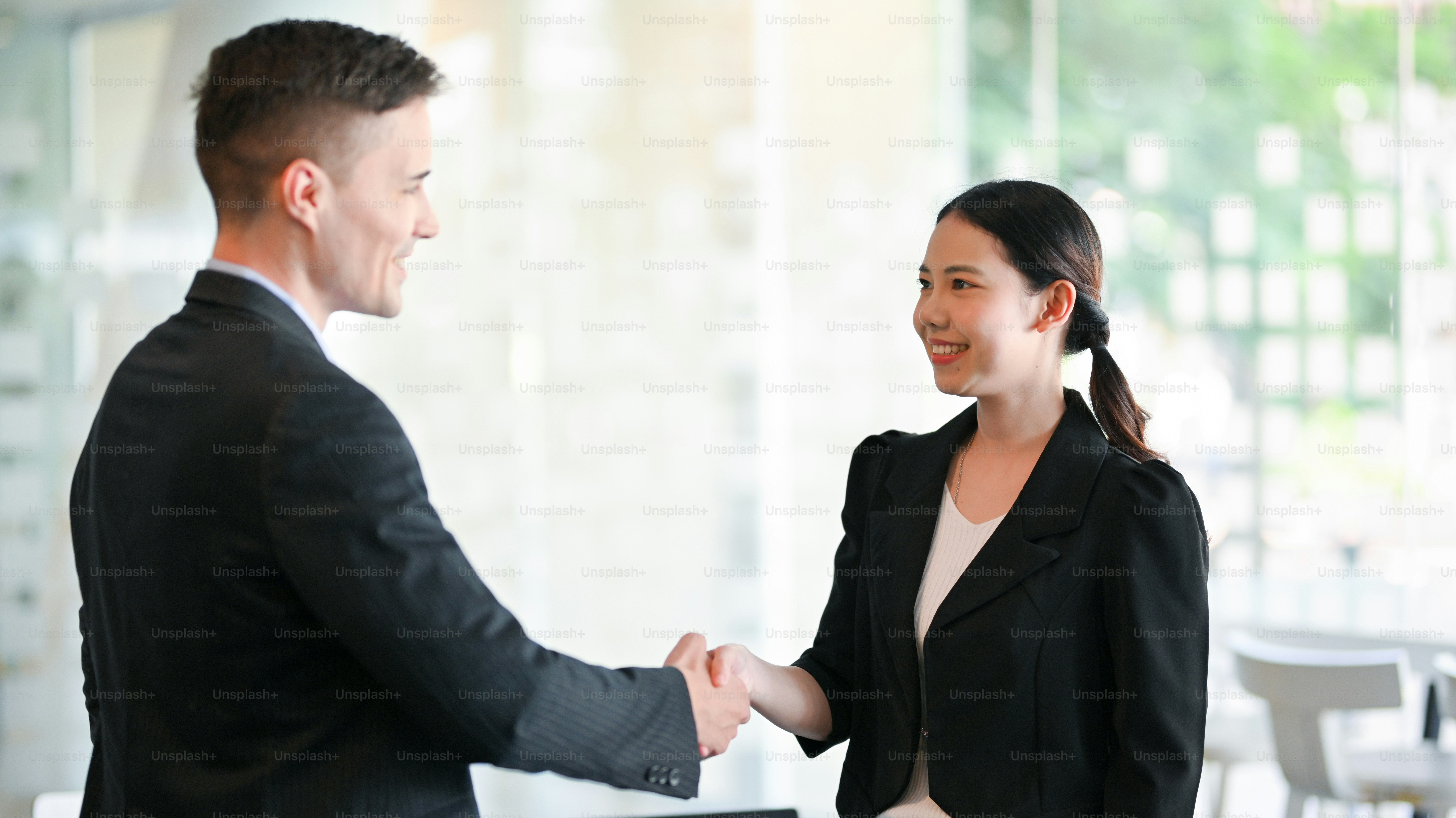 Handsome caucasian male boss greeting and handshaking new employee in ...