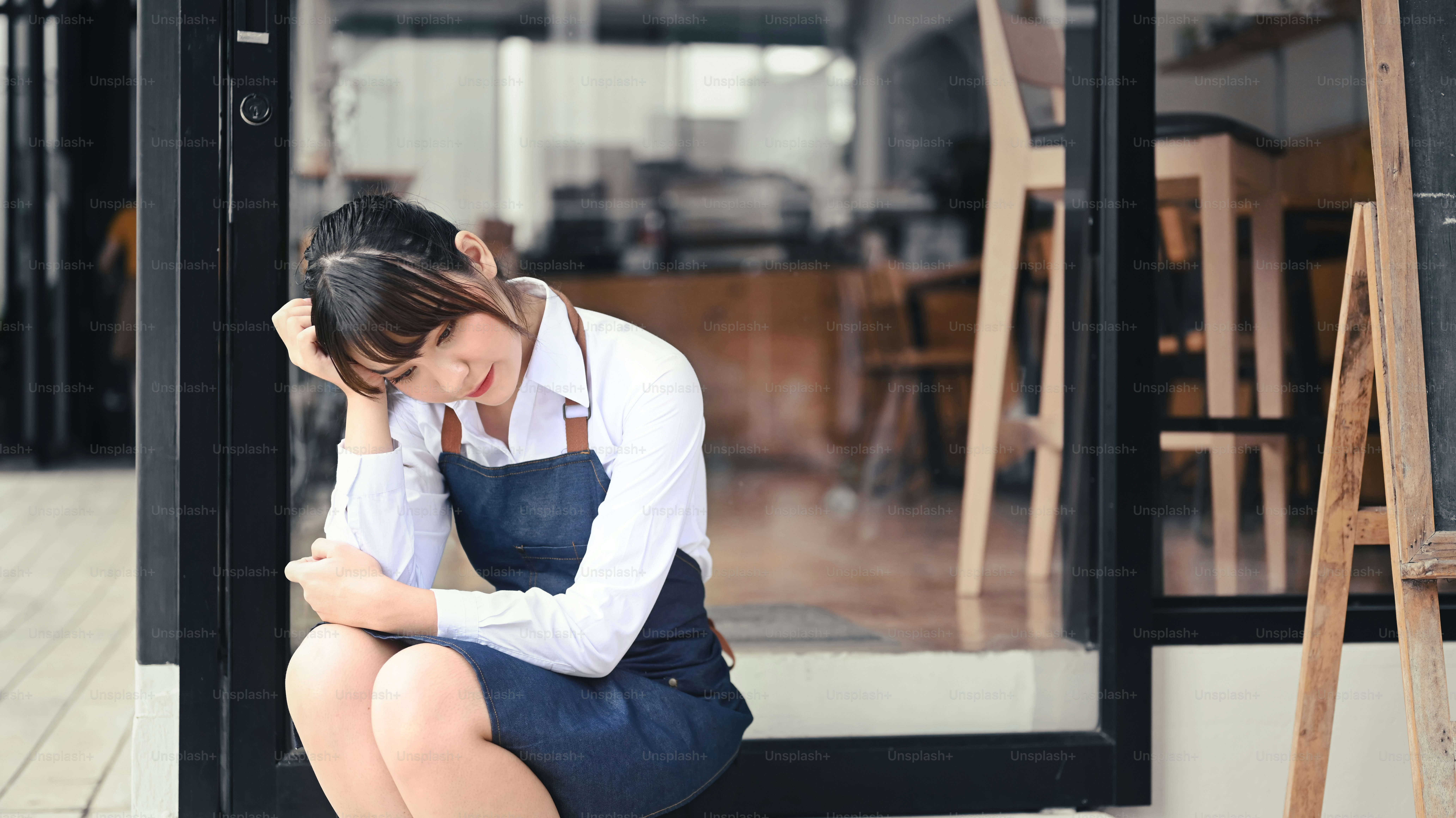 Stressed small business entrepreneur sitting in front of her coffee ...
