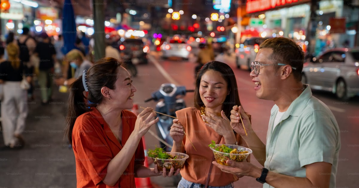 アジアの女性とlgbtqの人々の友人の4kグループは、タイのバンコクのチャイナタウンストリートナイトマーケットで、伝統的な屋台の食べ物の