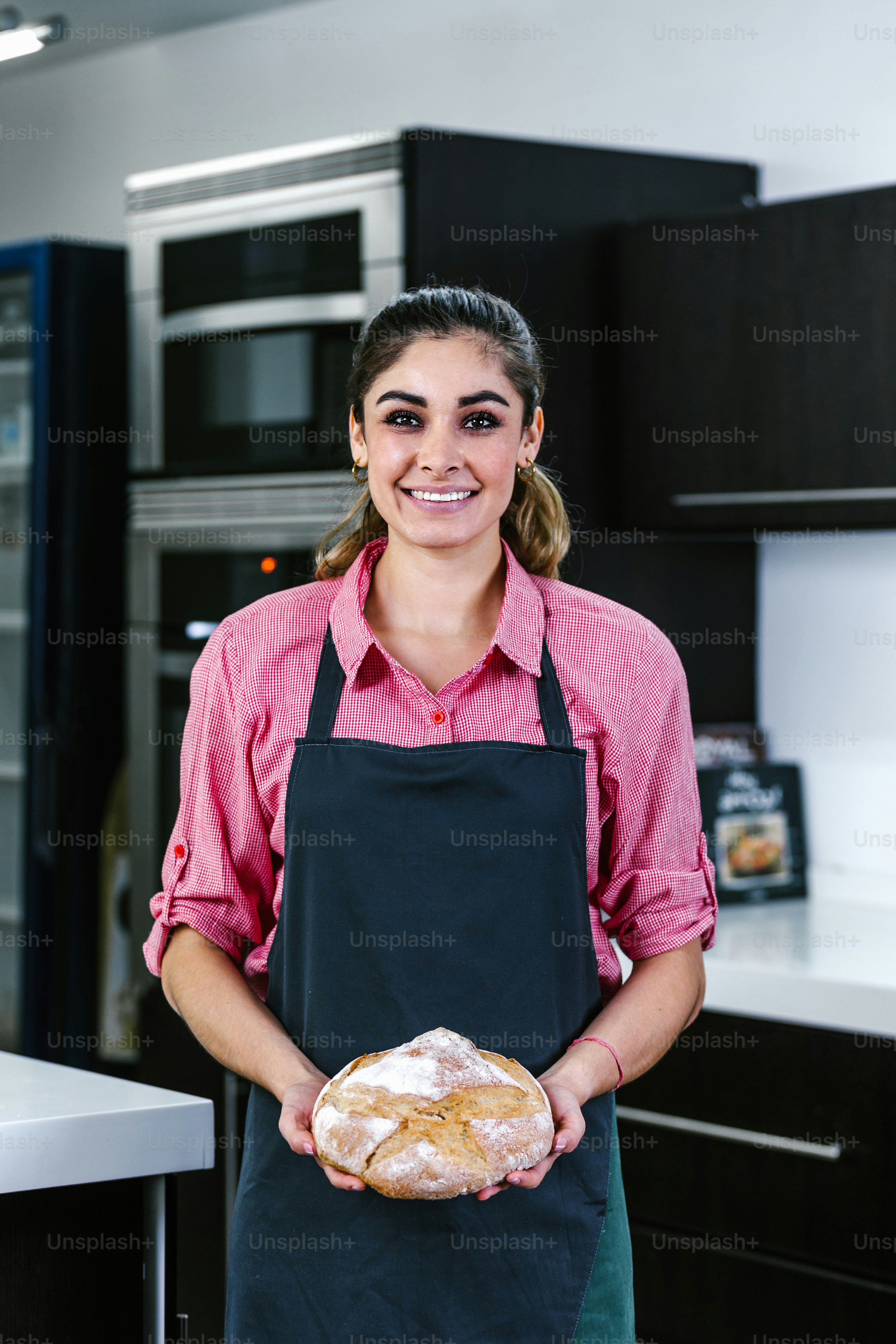 Young Latin woman holding piece of bread in kitchen in Mexico Latin ...
