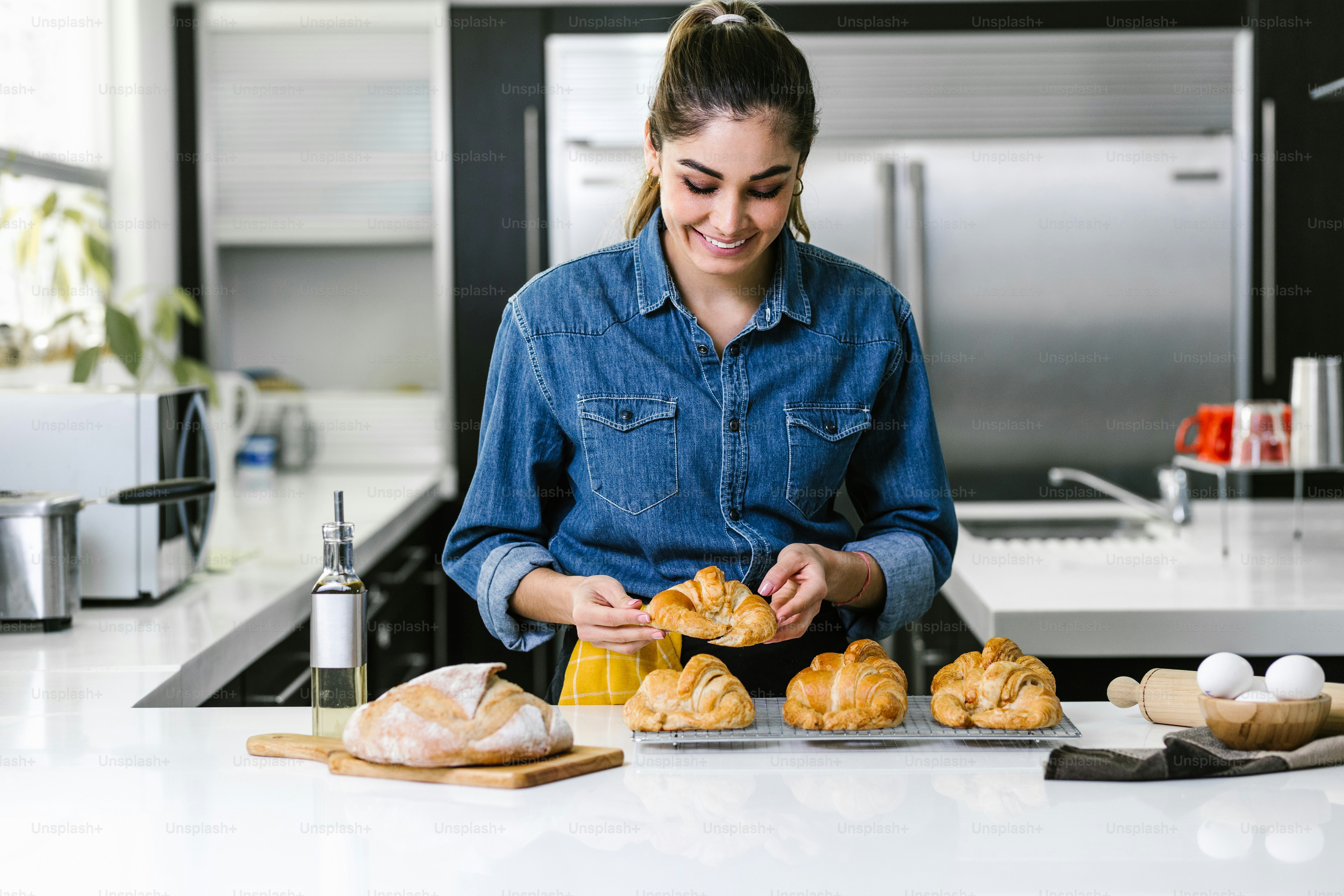 Young Latin woman baking croissant ingredients in kitchen in Mexico ...