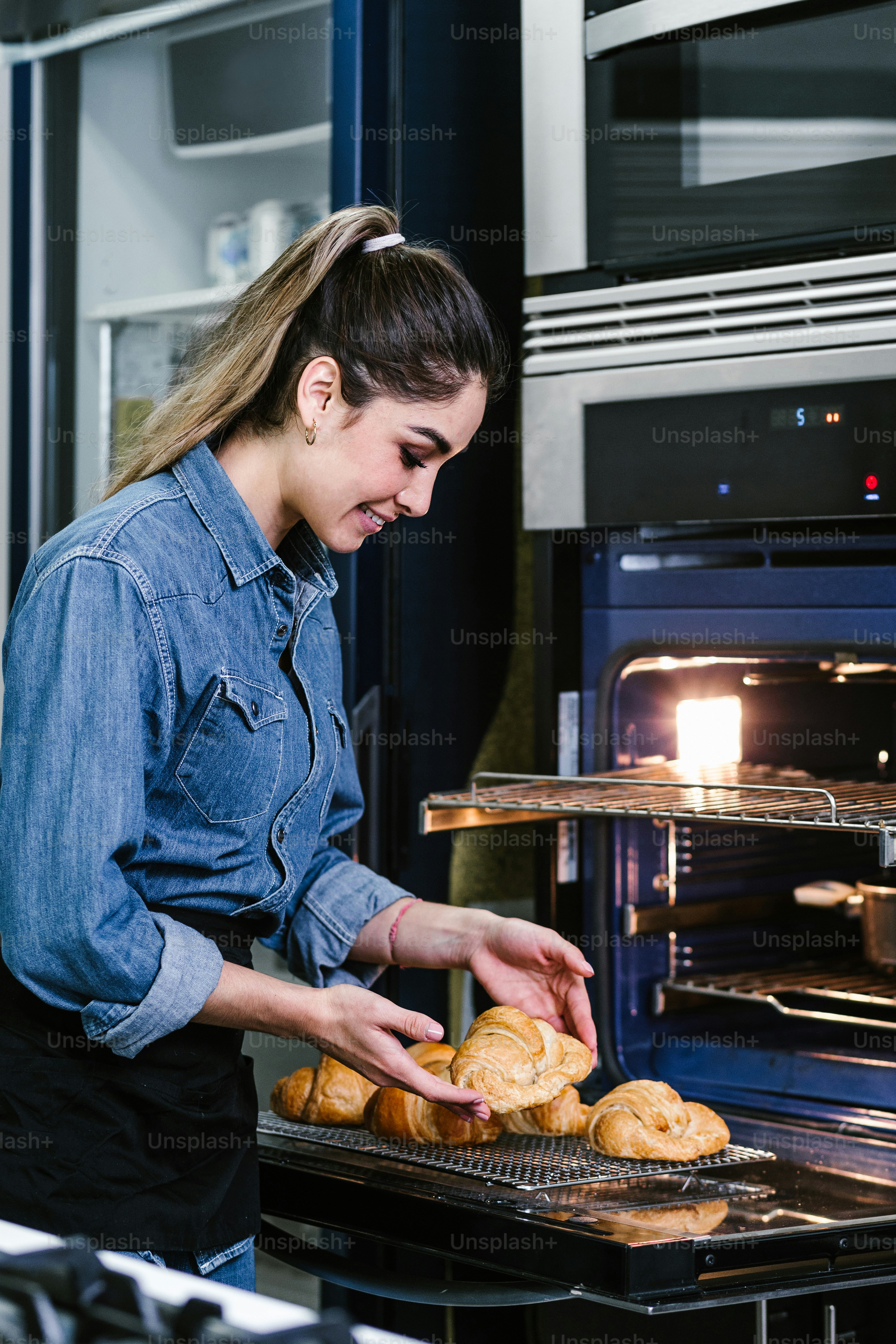 Foto Joven mujer latina horneando croissant en el horno en la cocina en ...