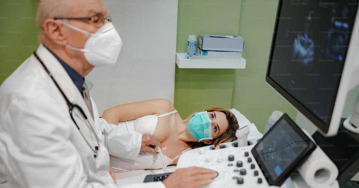 숙련 된 수석 의사가 젊은 여성 환자에게 심장 검사를 수행합니다 그는 심장학 스캐너를 사용하고 있습니다 의학과 현대 기술