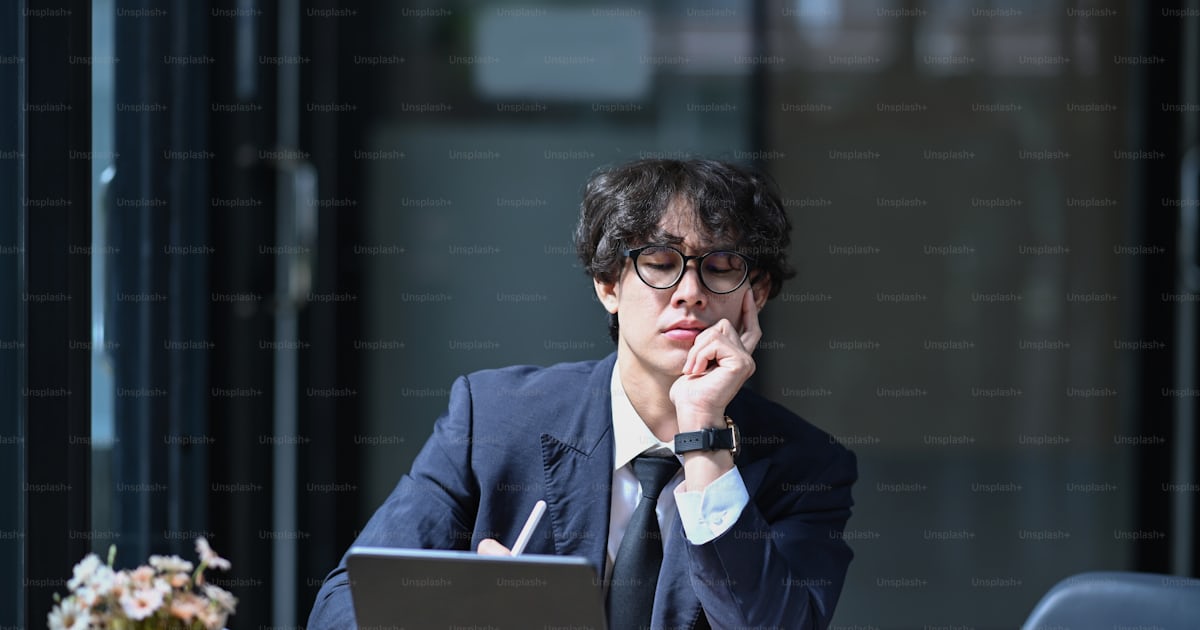 밝은 사무실에서 컴퓨터로 일하는 사려 깊은 젊은 사업가 사진 Unsplash의 사업 이미지