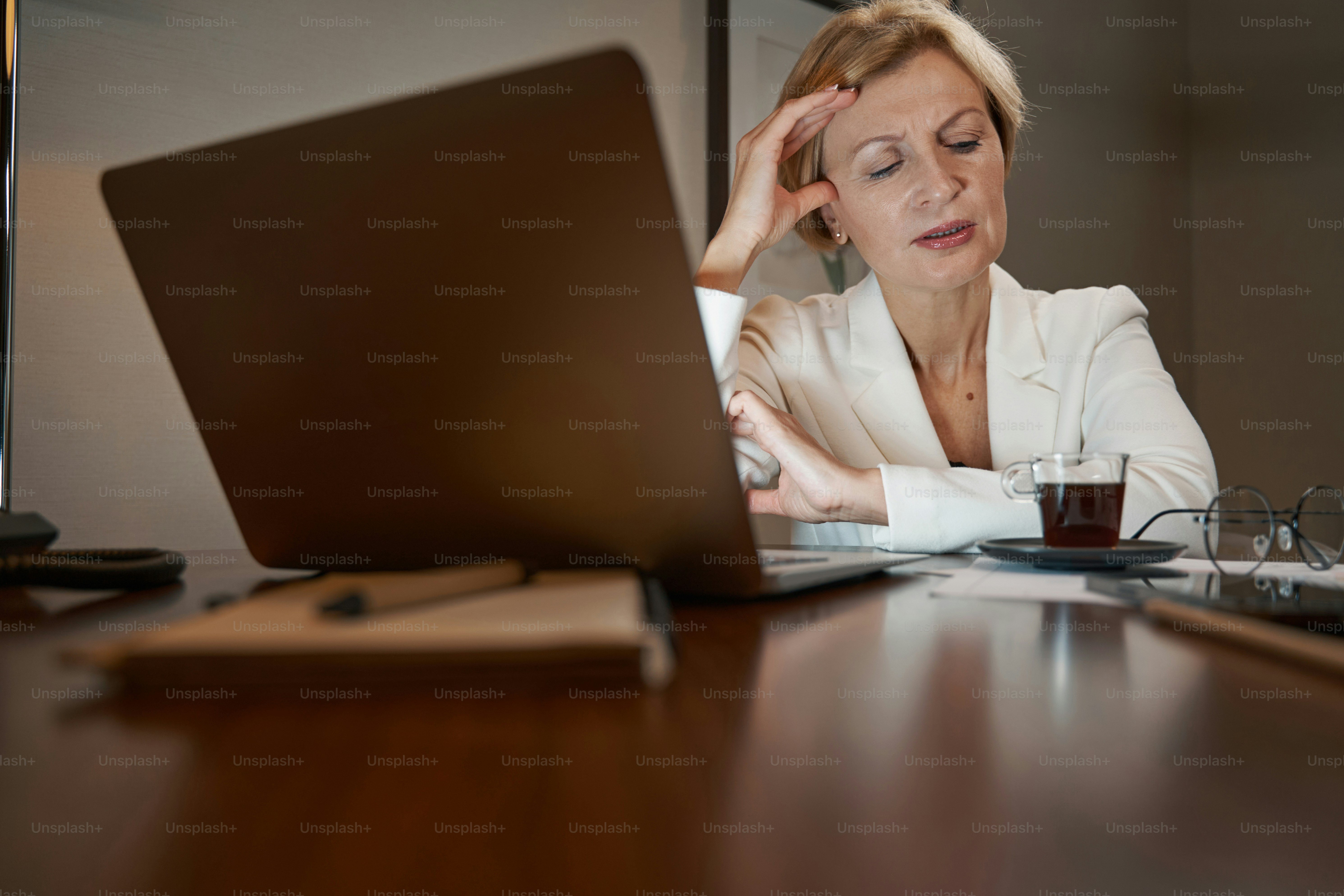 Close-up photo of weary woamn looking at documants, while sitting at ...
