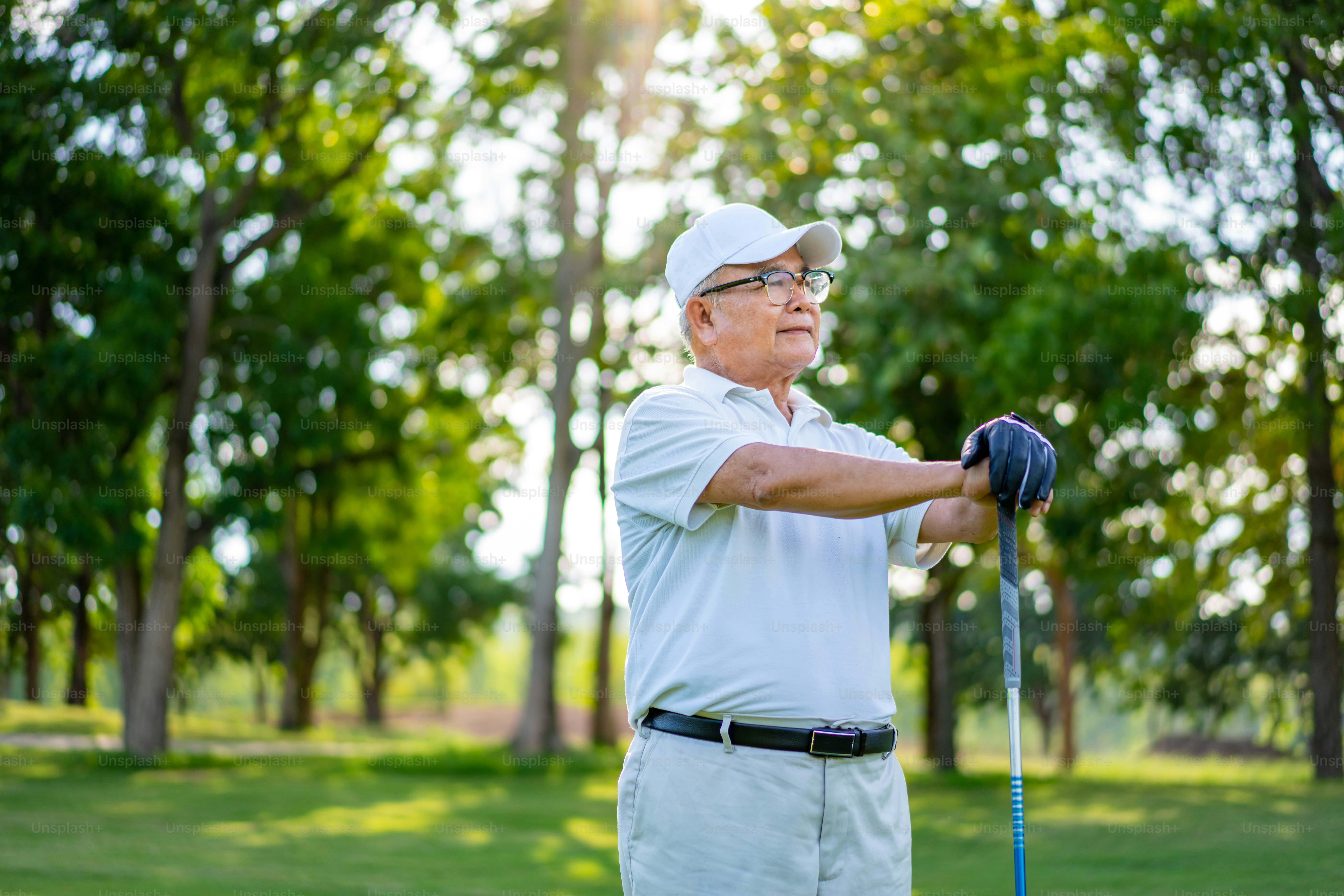 Confidence Asian man golfer holding golf club hitting golf ball on the ...