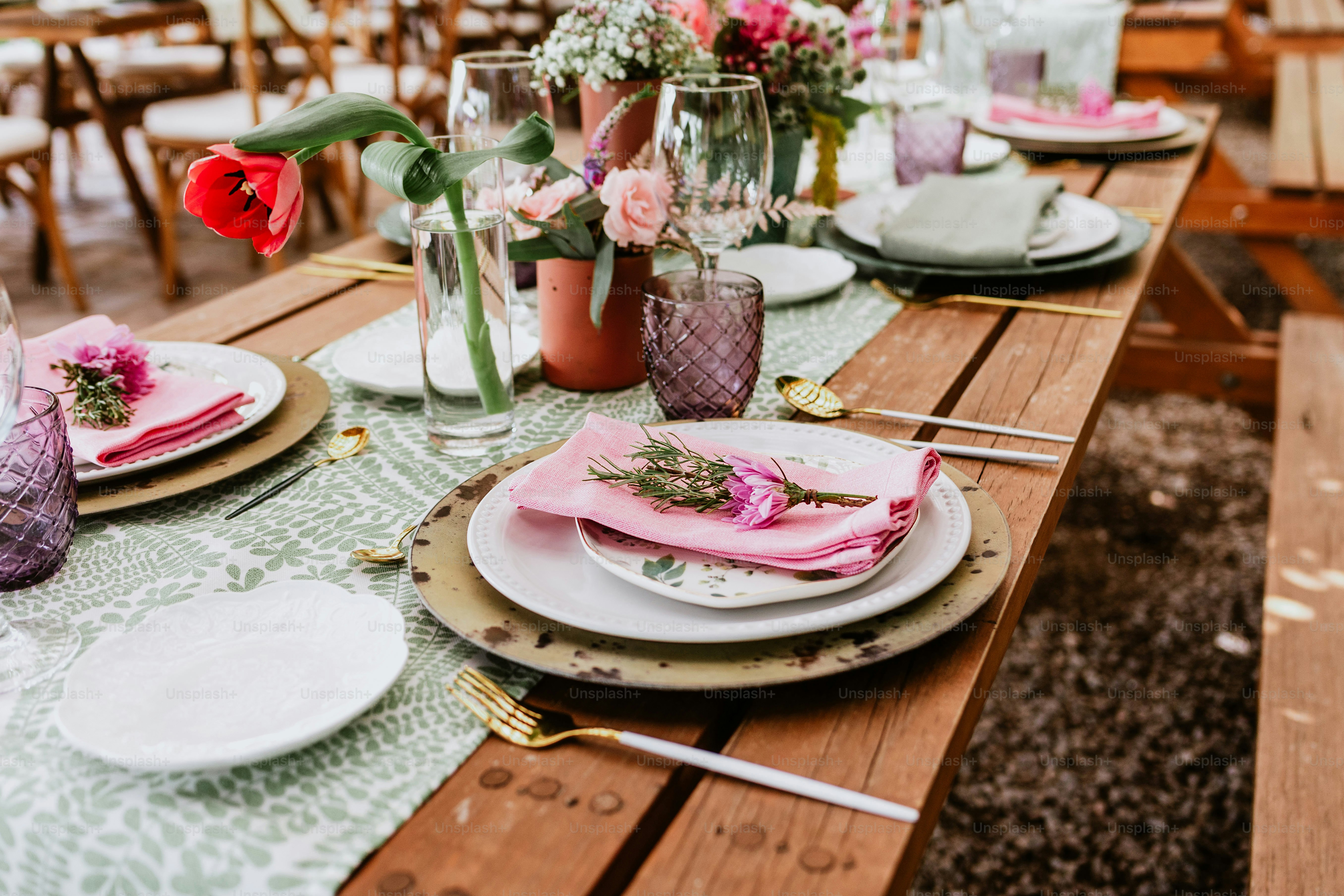 Terrace with tables setup with flowers and plates on table decorated ...