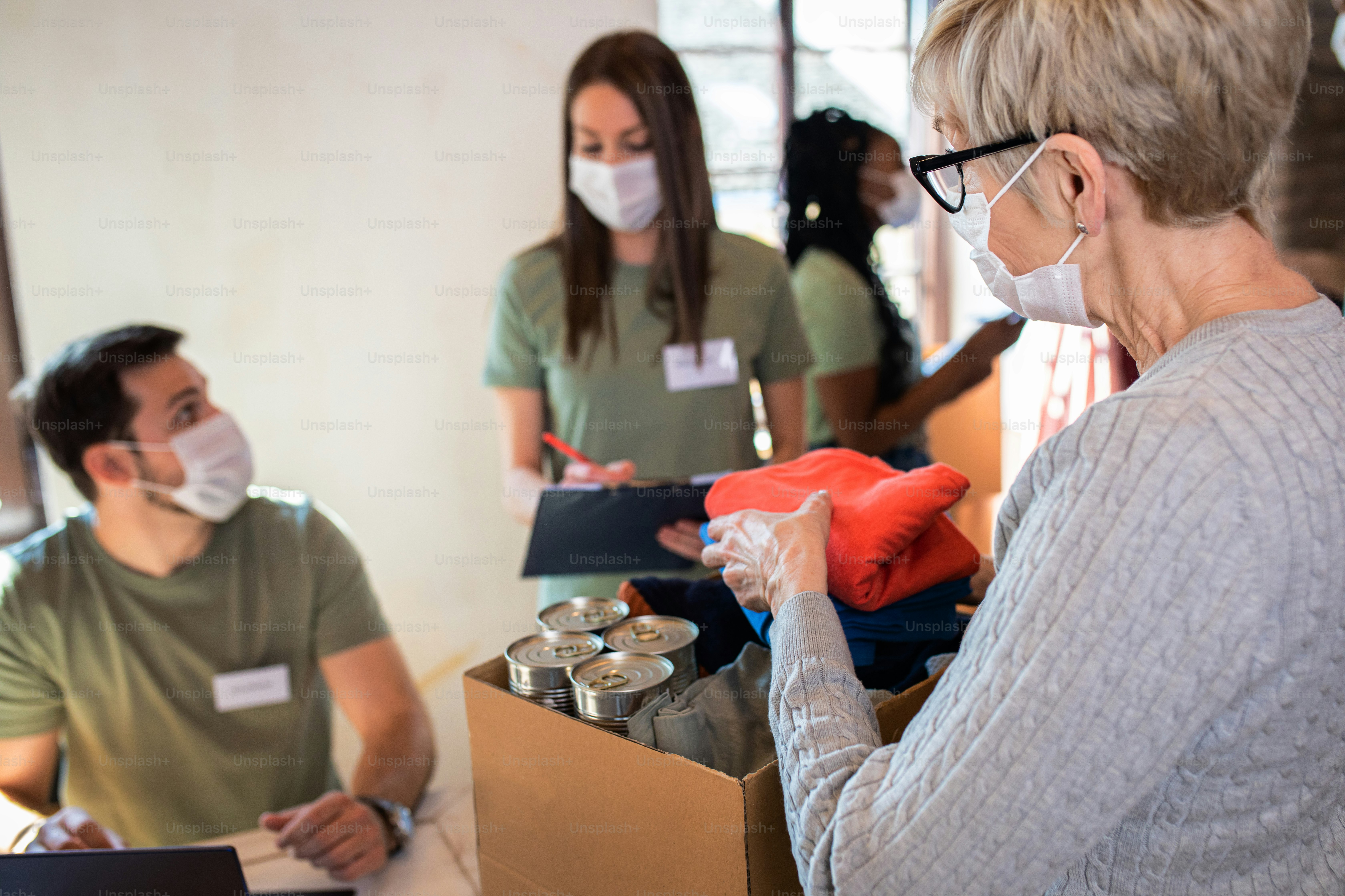 Group of volunteers with face mask working in community charity ...