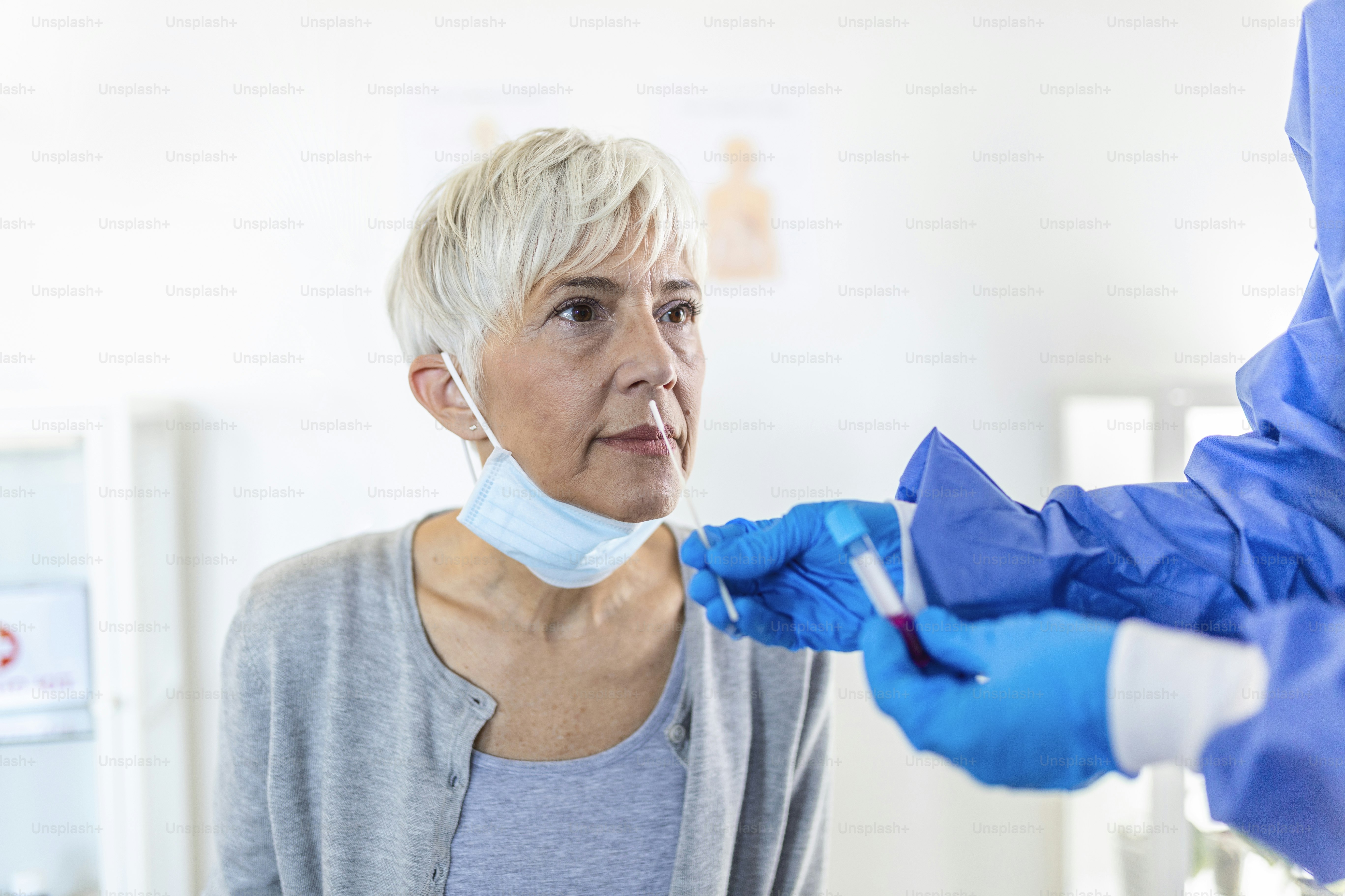 Physician wearing personal protective equipment performing a ...