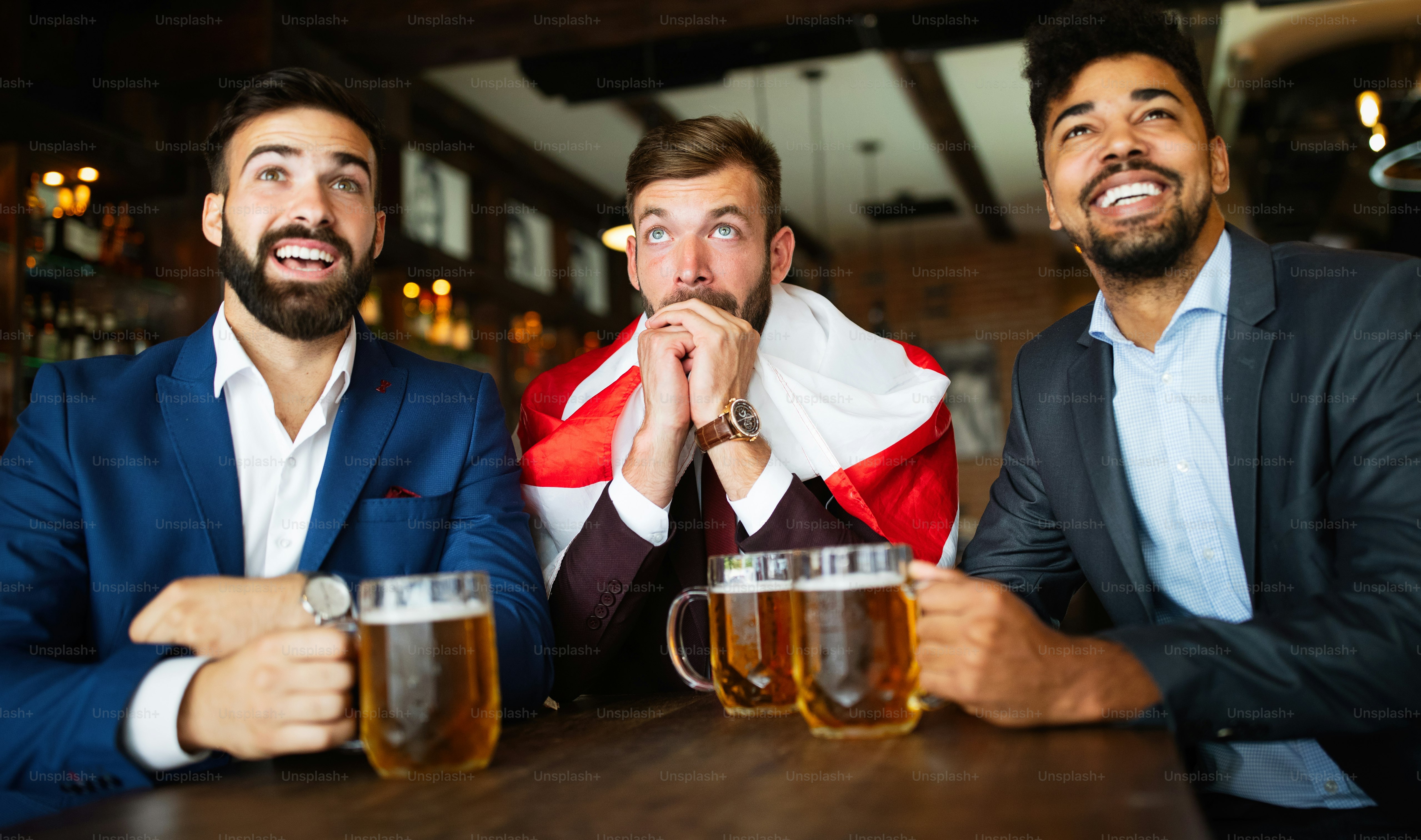 Business men fans screaming and watching football on TV and drink beer ...