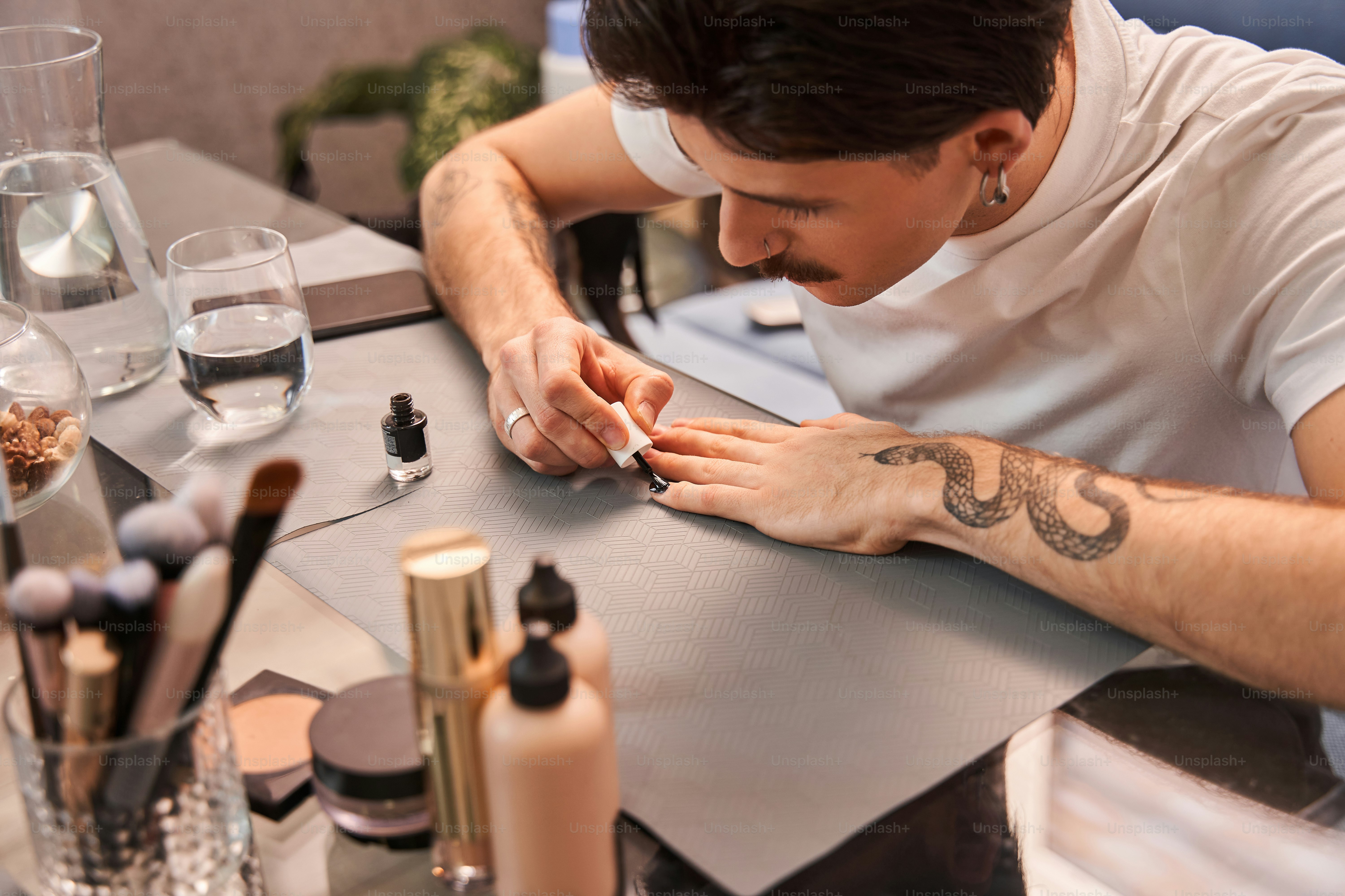Tiempo para mí. Retrato del chico guapo y agradable que hace manicura ...