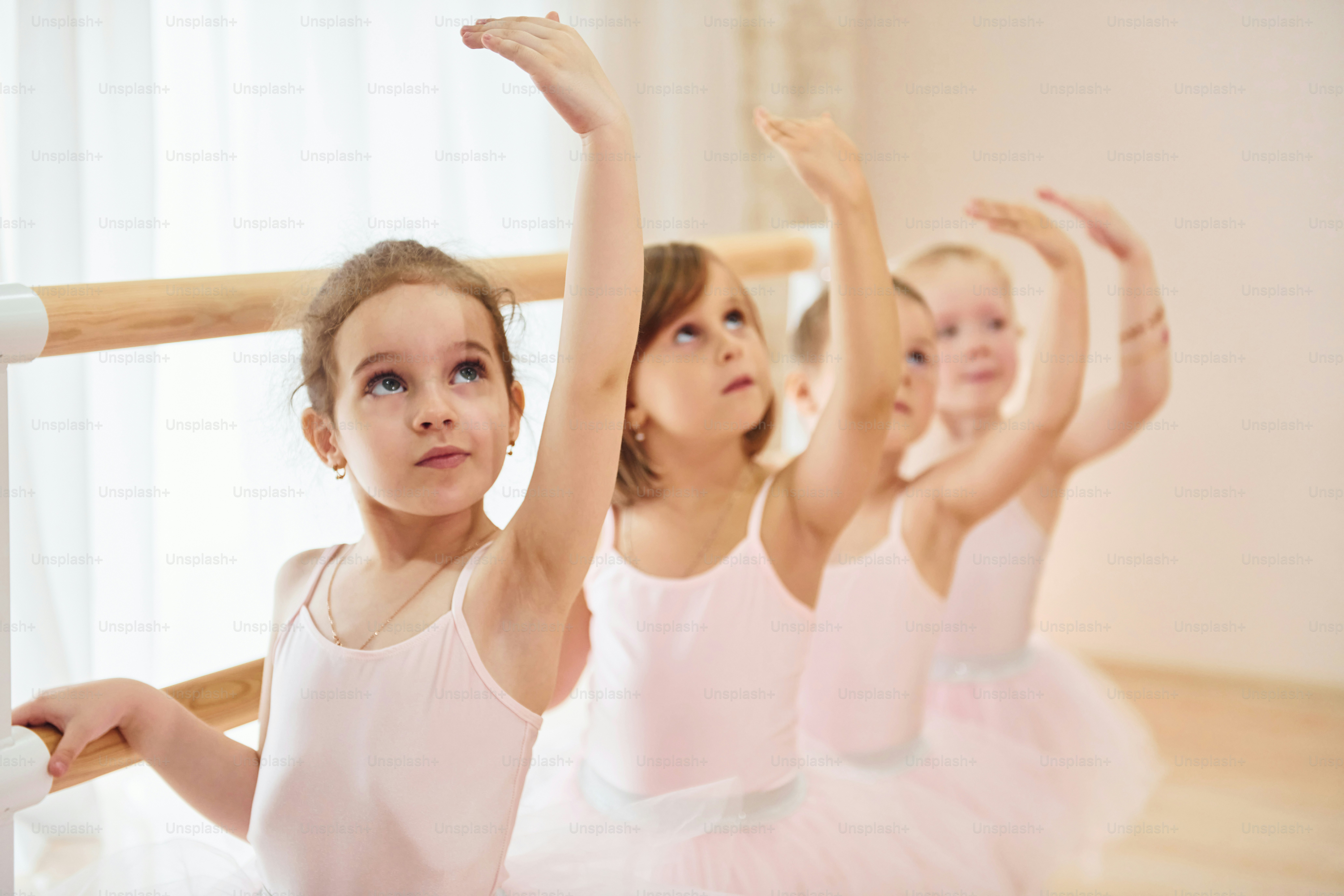Little ballerinas preparing for performance by practicing dance moves ...
