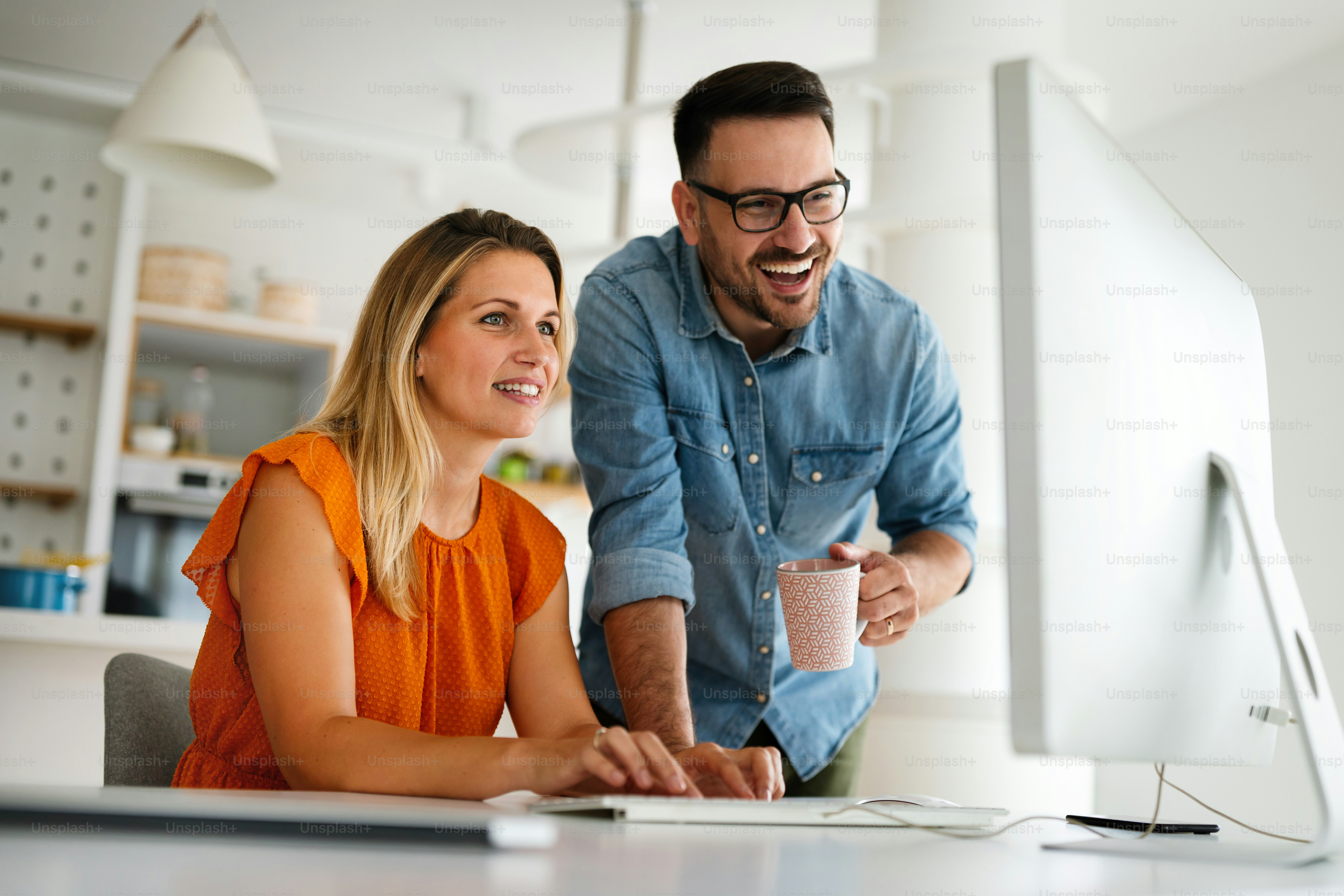 Happy couple doing business together working at small office. People ...