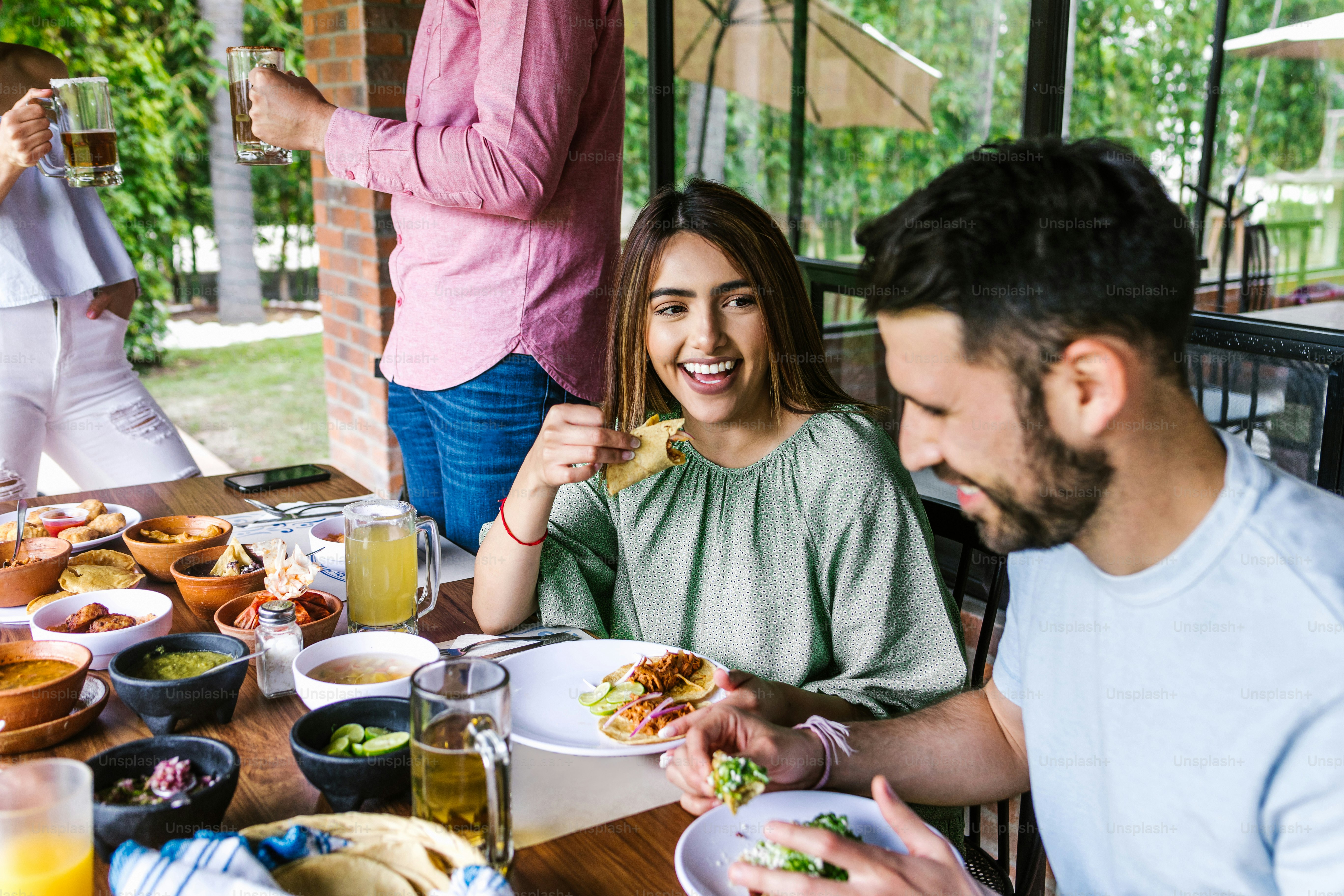 Foto Grupo de amigos latinos comiendo comida mexicana en la terraza del ...