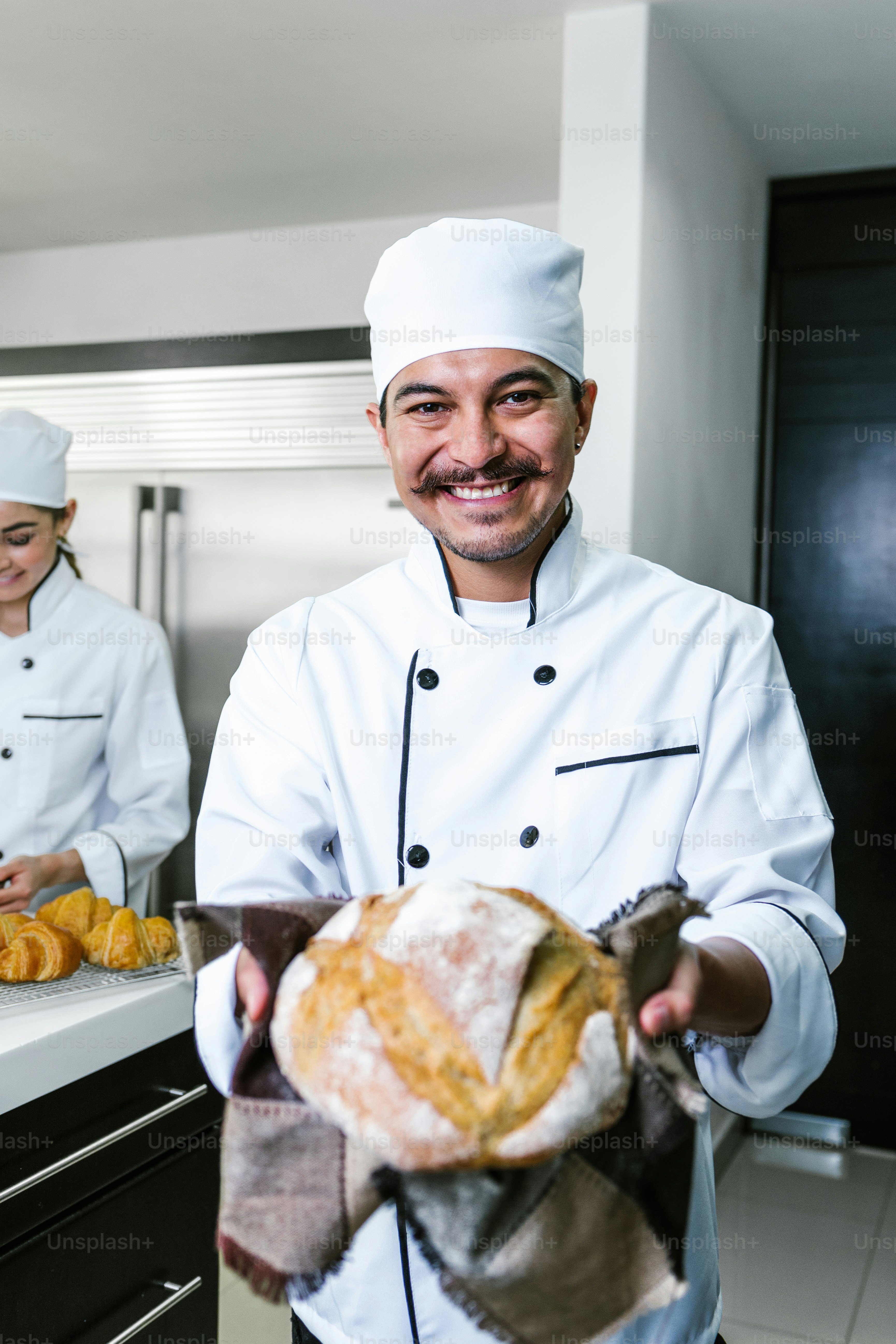 Young Latin man baker and baking bread on oven at kitchen in Mexico ...