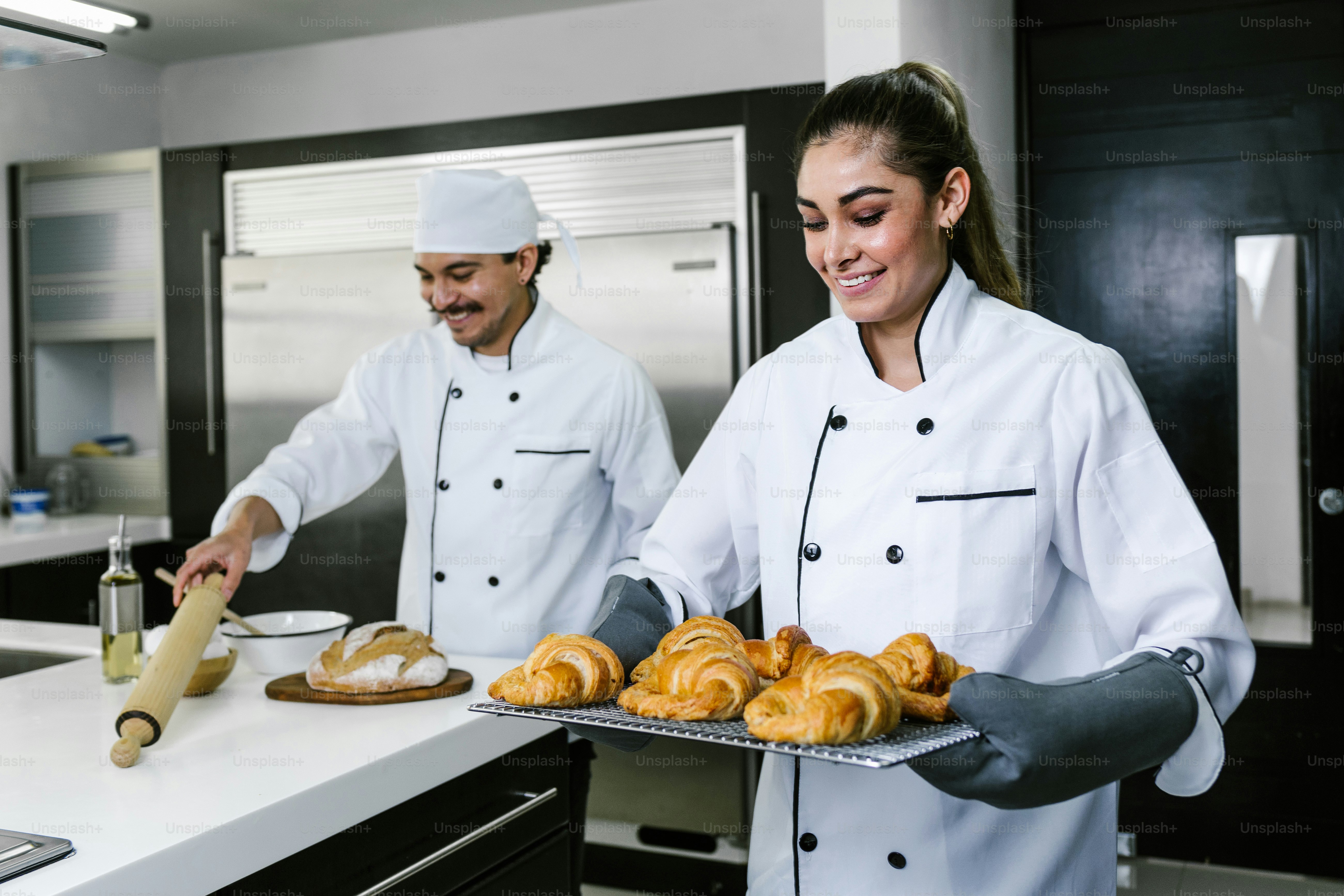 Young Latin woman baking croissant bread on oven at kitchen in Mexico ...