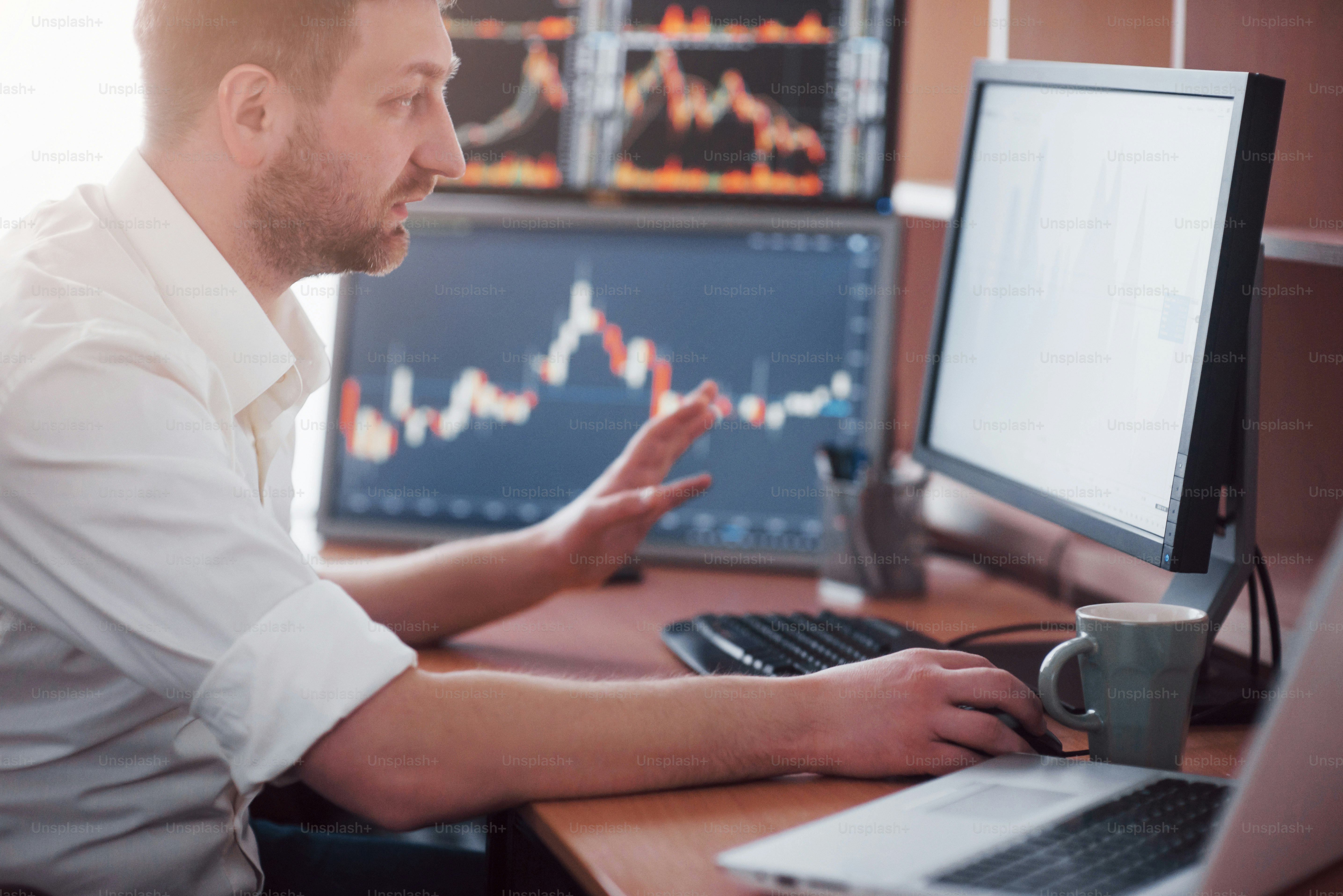 Stockbroker in shirt is working in a monitoring room with display ...