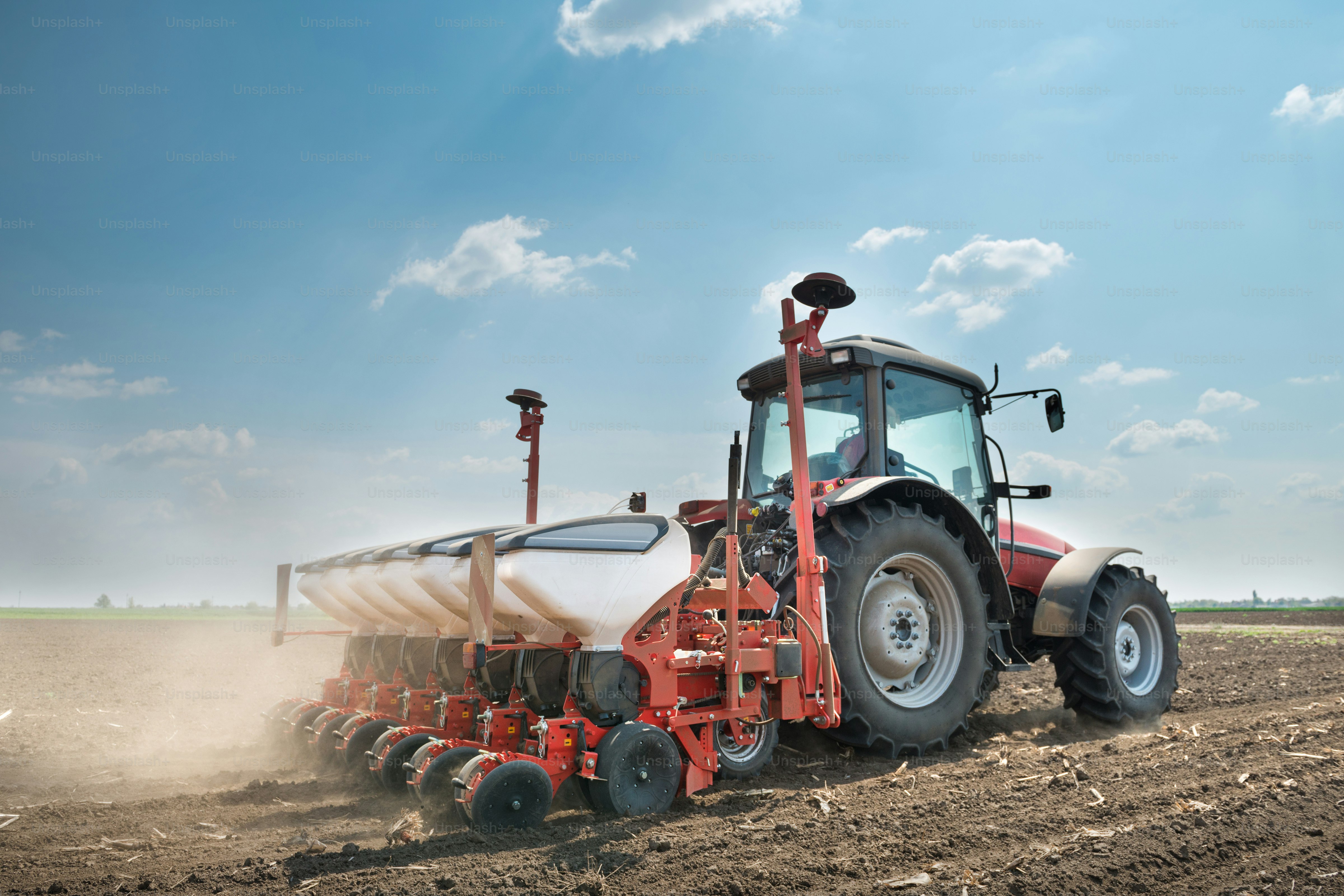 Tractor and seeder planting crops on a field photo – Tractor Image on ...