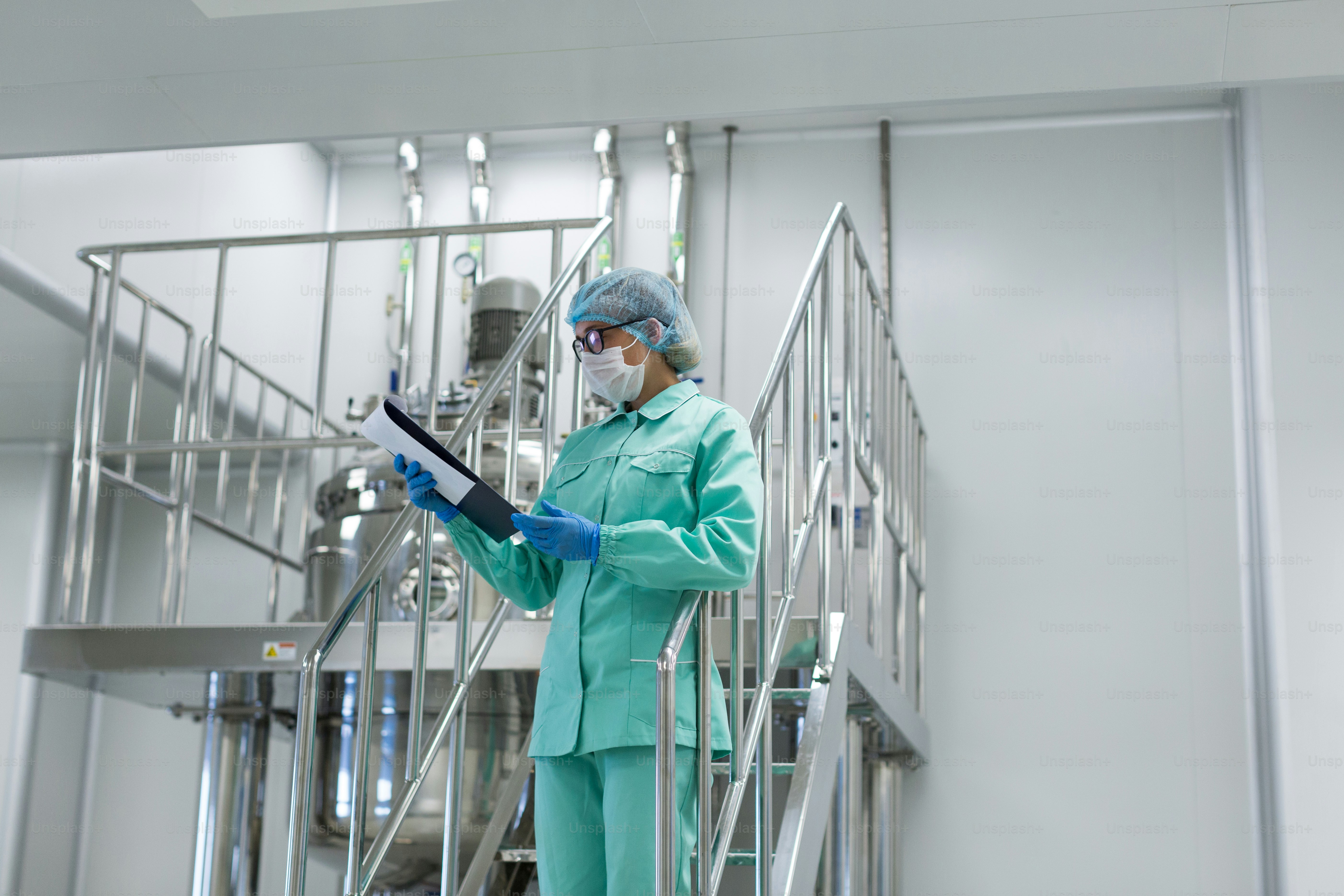 Scientist woman in blue suit looking in tablet, standing on stairs ...