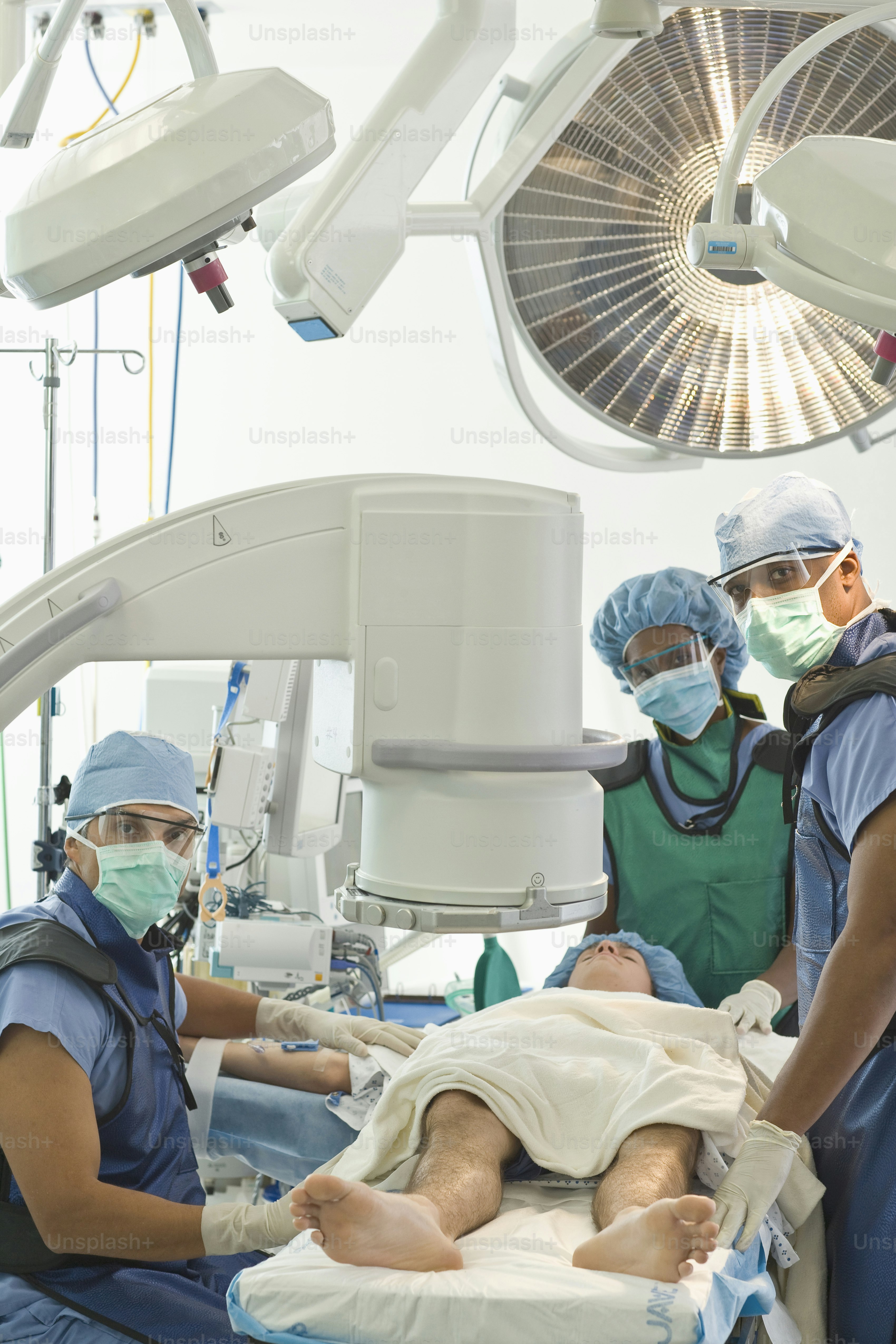 A group of doctors performing surgery on a patient photo – Doctor Image ...