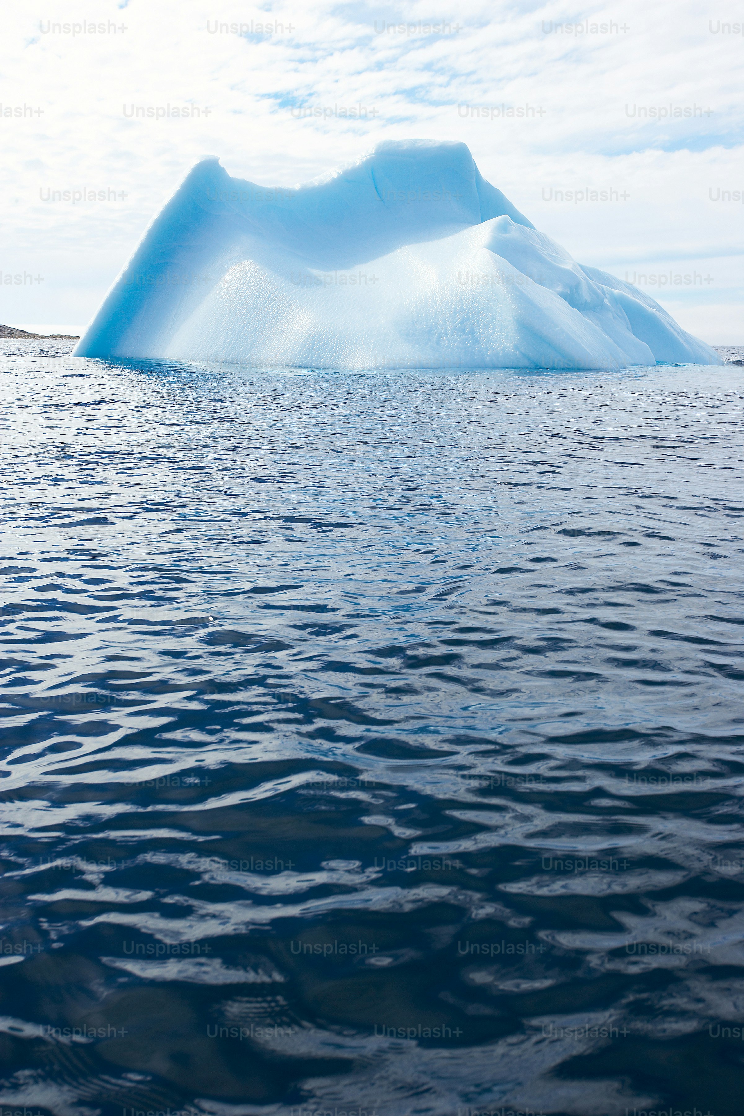 A large iceberg floating on top of a body of water photo – Icebergs ...
