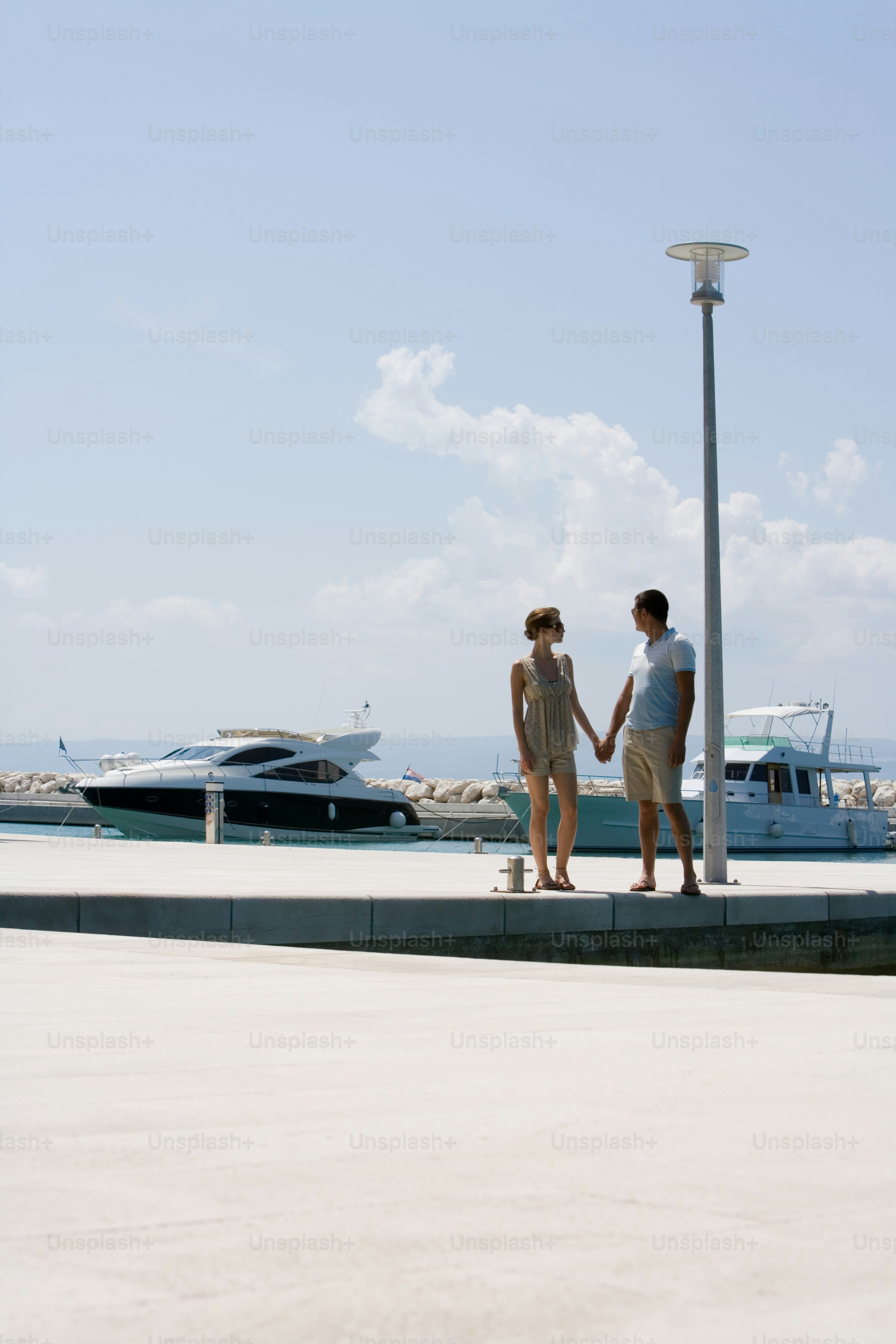 A couple of people that are standing by a pole photo – Vertical Image ...