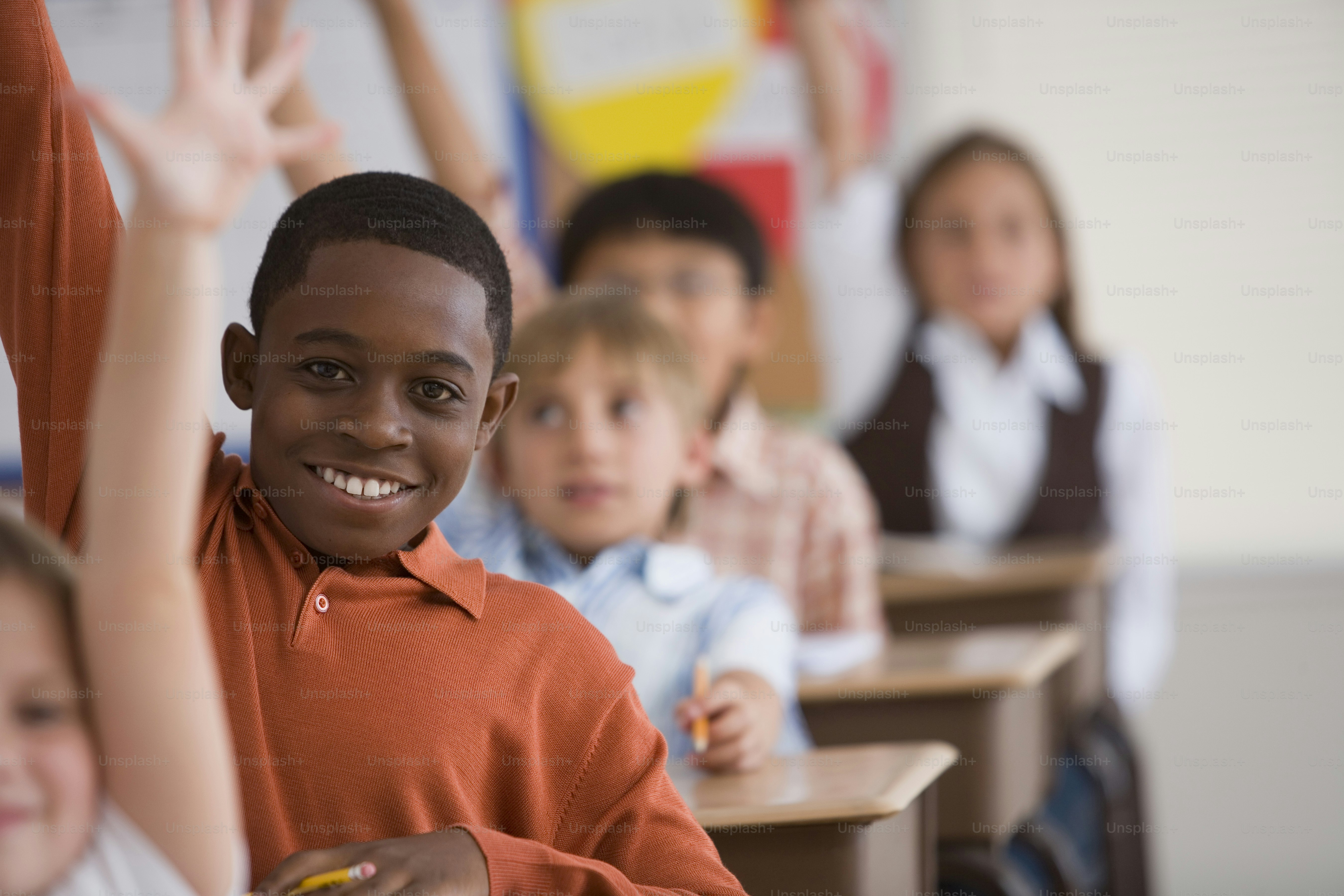 A group of children sitting at desks in a classroom photo – Student ...