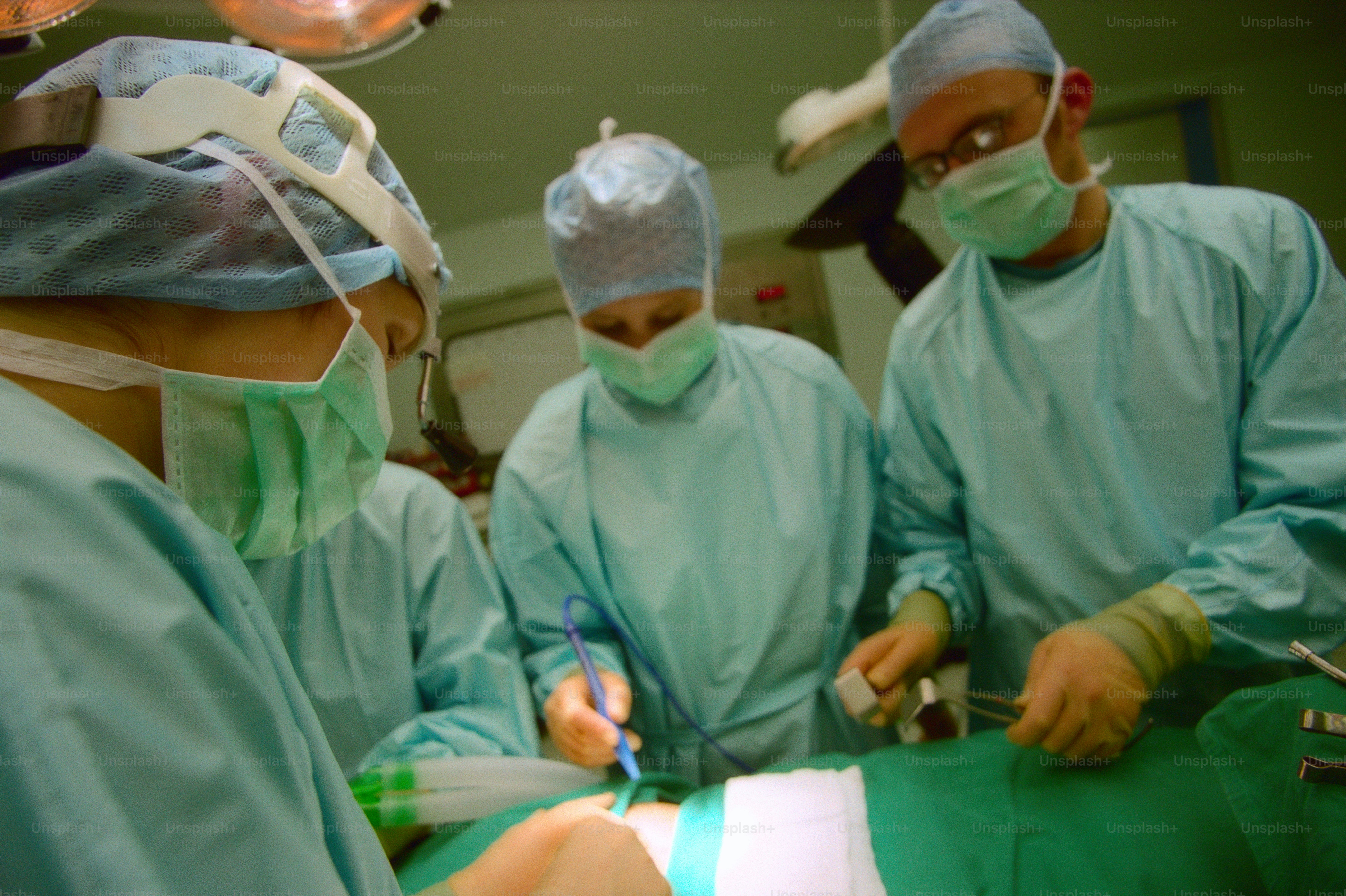 A group of doctors performing surgery in a hospital photo – Hospital ...