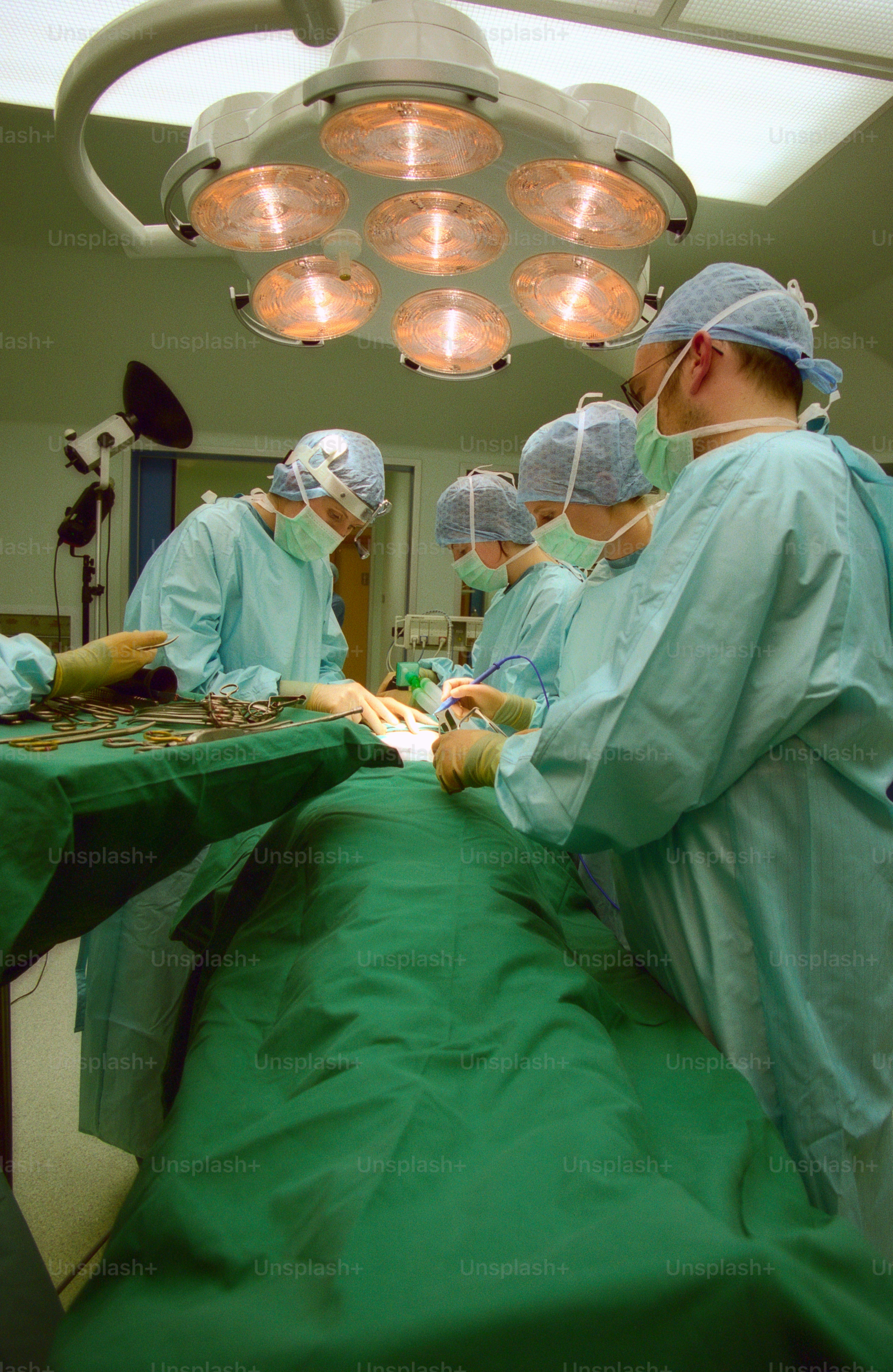 A group of doctors performing surgery in a hospital photo – Doctor ...