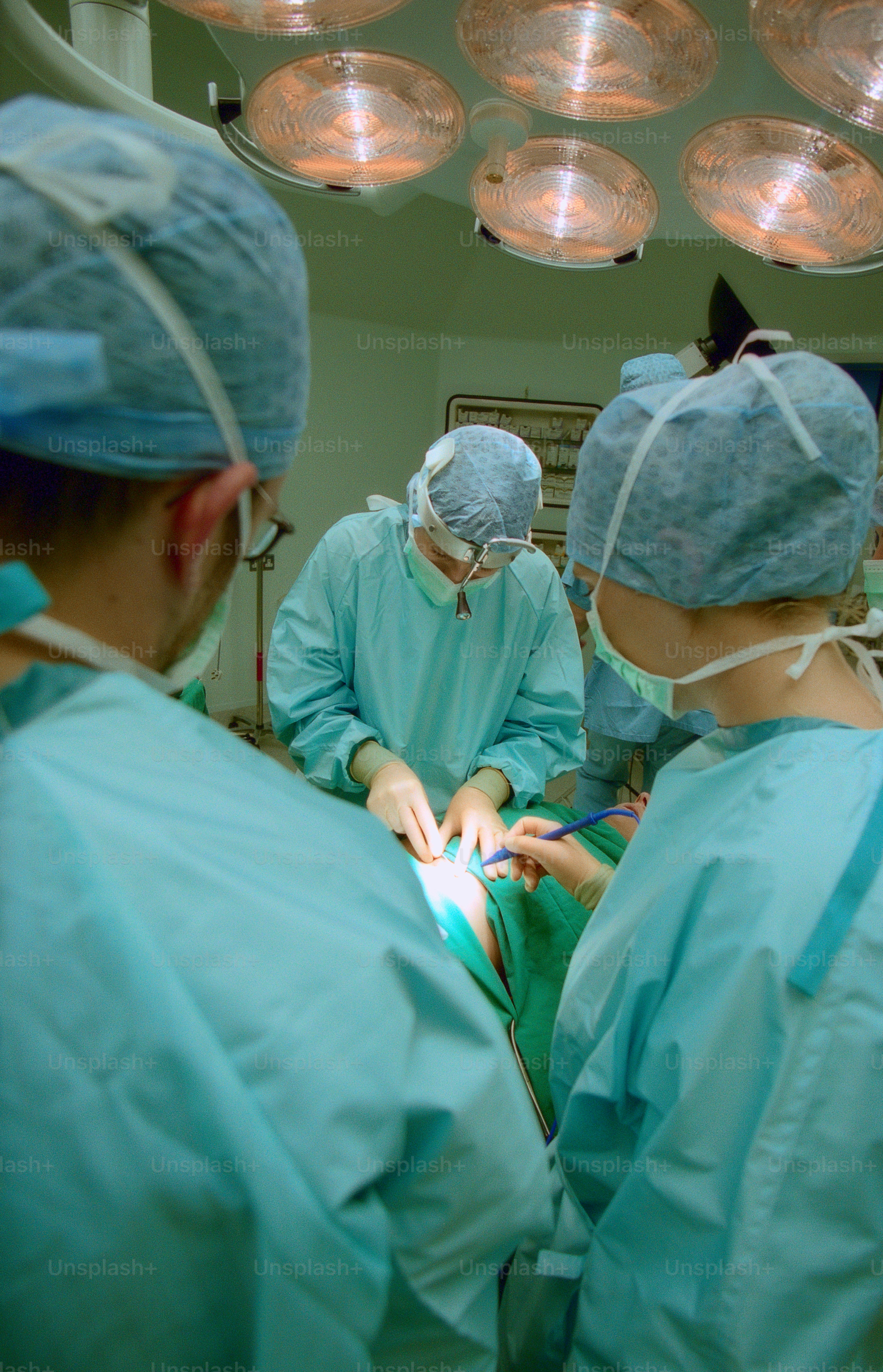 A group of doctors performing surgery in a hospital photo – Doctor ...