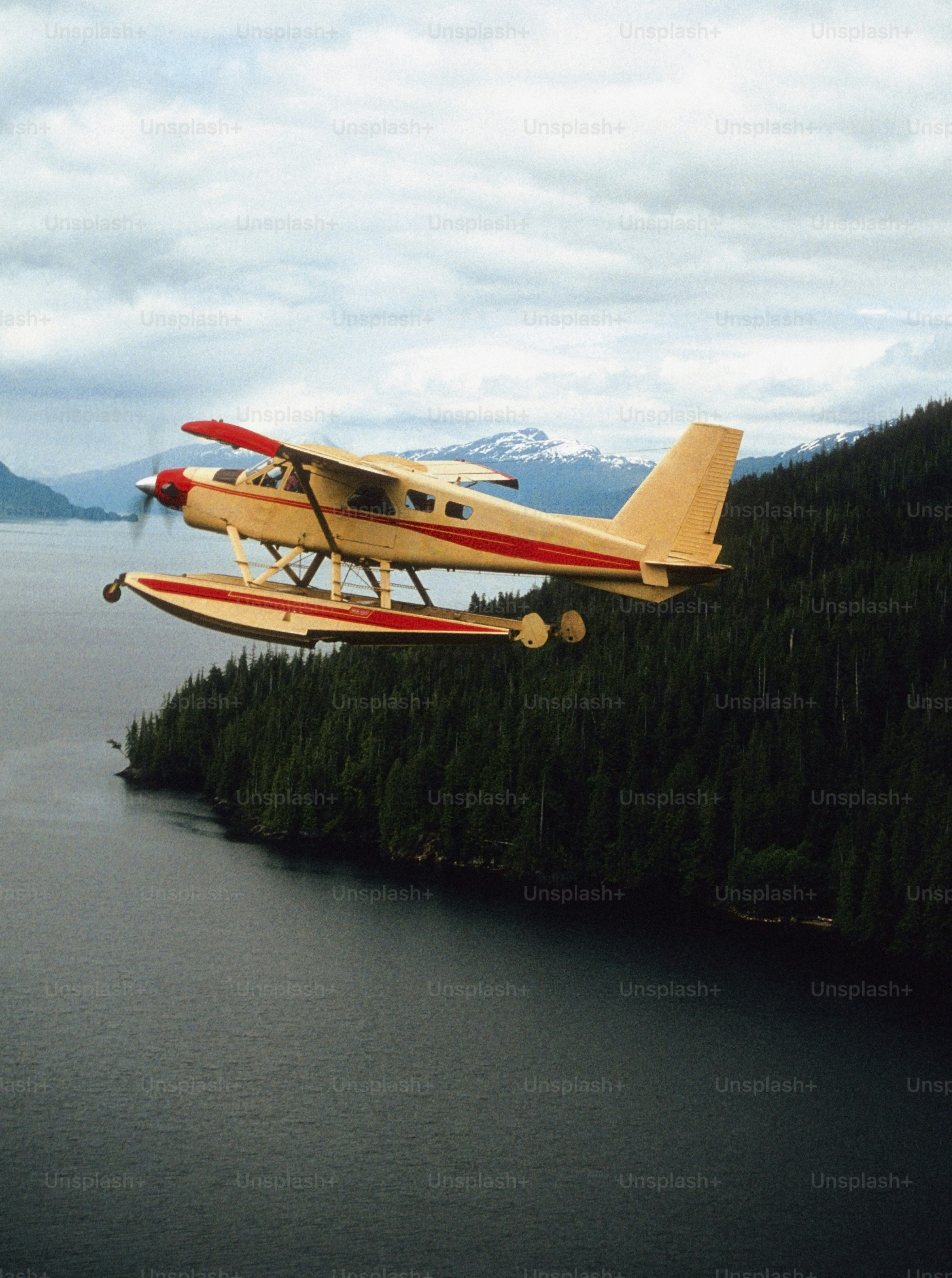 A small plane flying over a large body of water photo – Seaplane Image ...