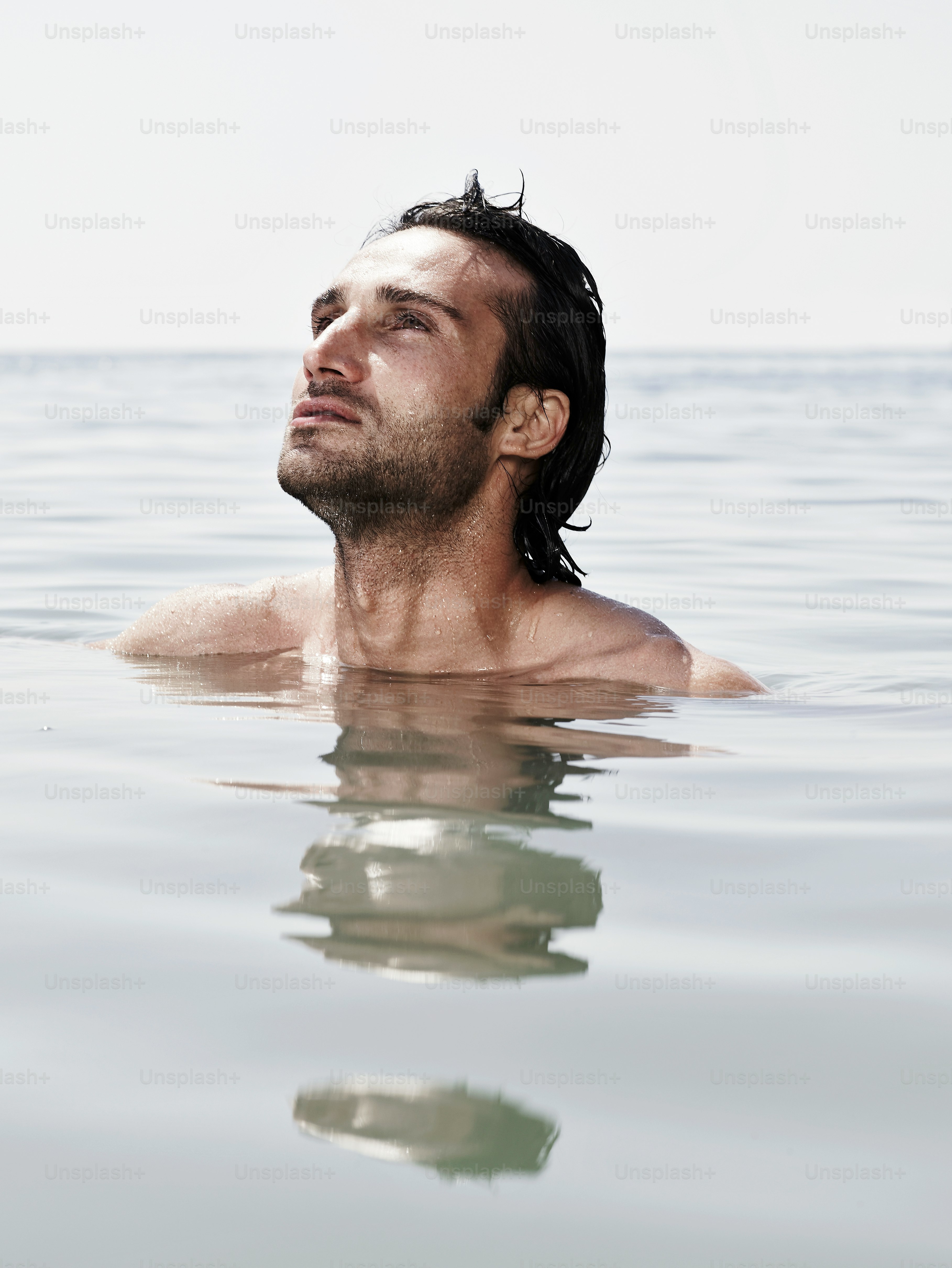 A man floating in the water with his head above the water photo – Spain ...