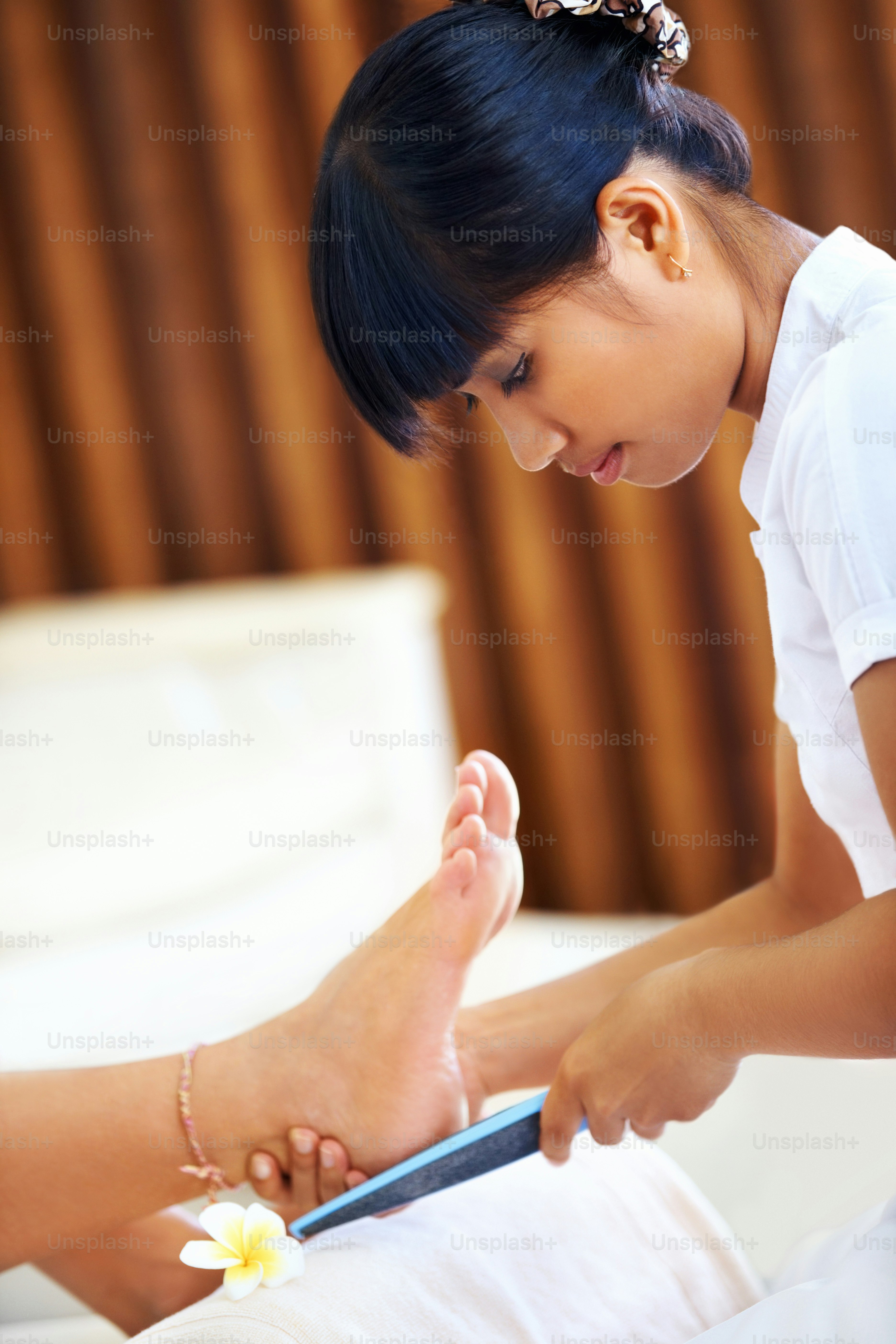 Pretty young girl gives a relaxing pedicure at a spa photo – Ethnicity ...