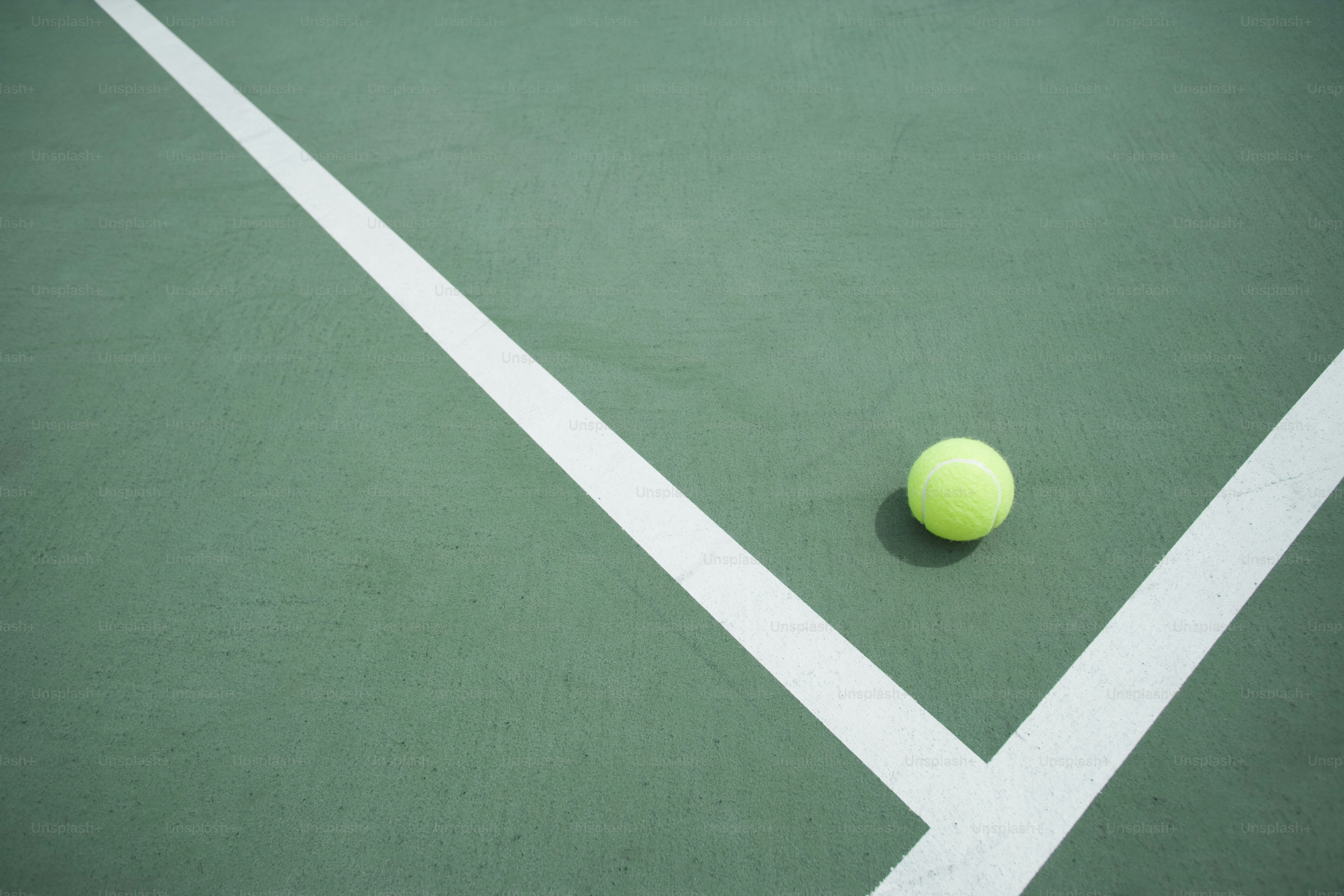 A tennis racket and two tennis balls on a tennis court photo – Sport ...