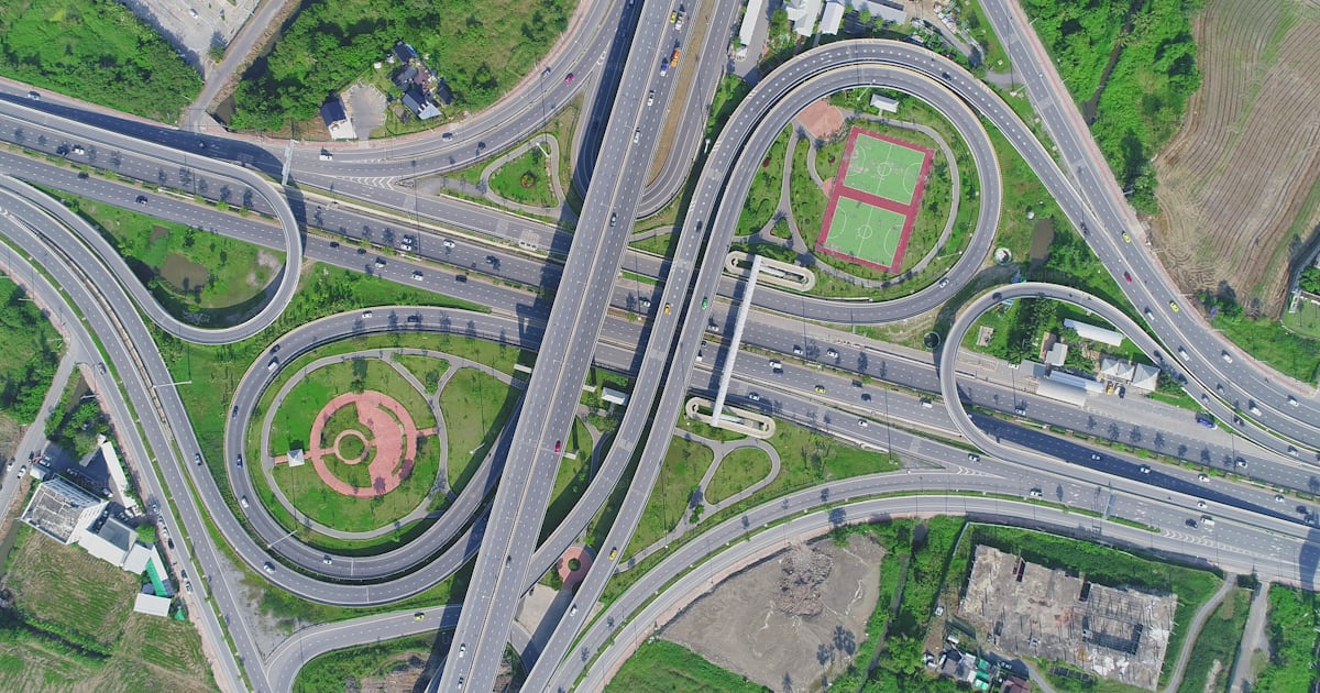 美しいパターンの航空写真高速道路の道路網の交差点の交通。輸入、輸出、または輸送のコンセプトに使用できます。の写真 Unsplashの旅行の画像