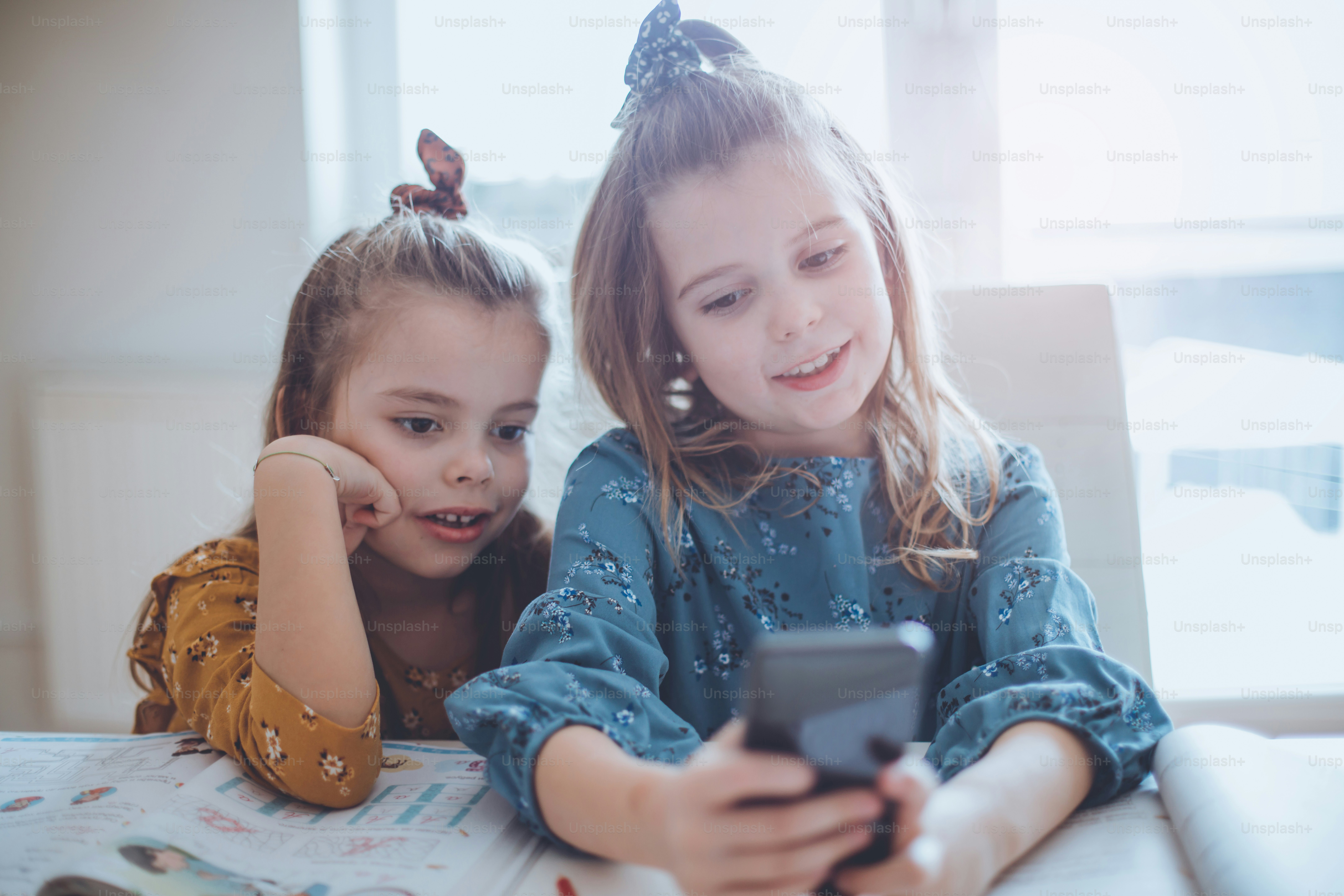 Let's ignore homework, let's take a picture. Two little school girls ...
