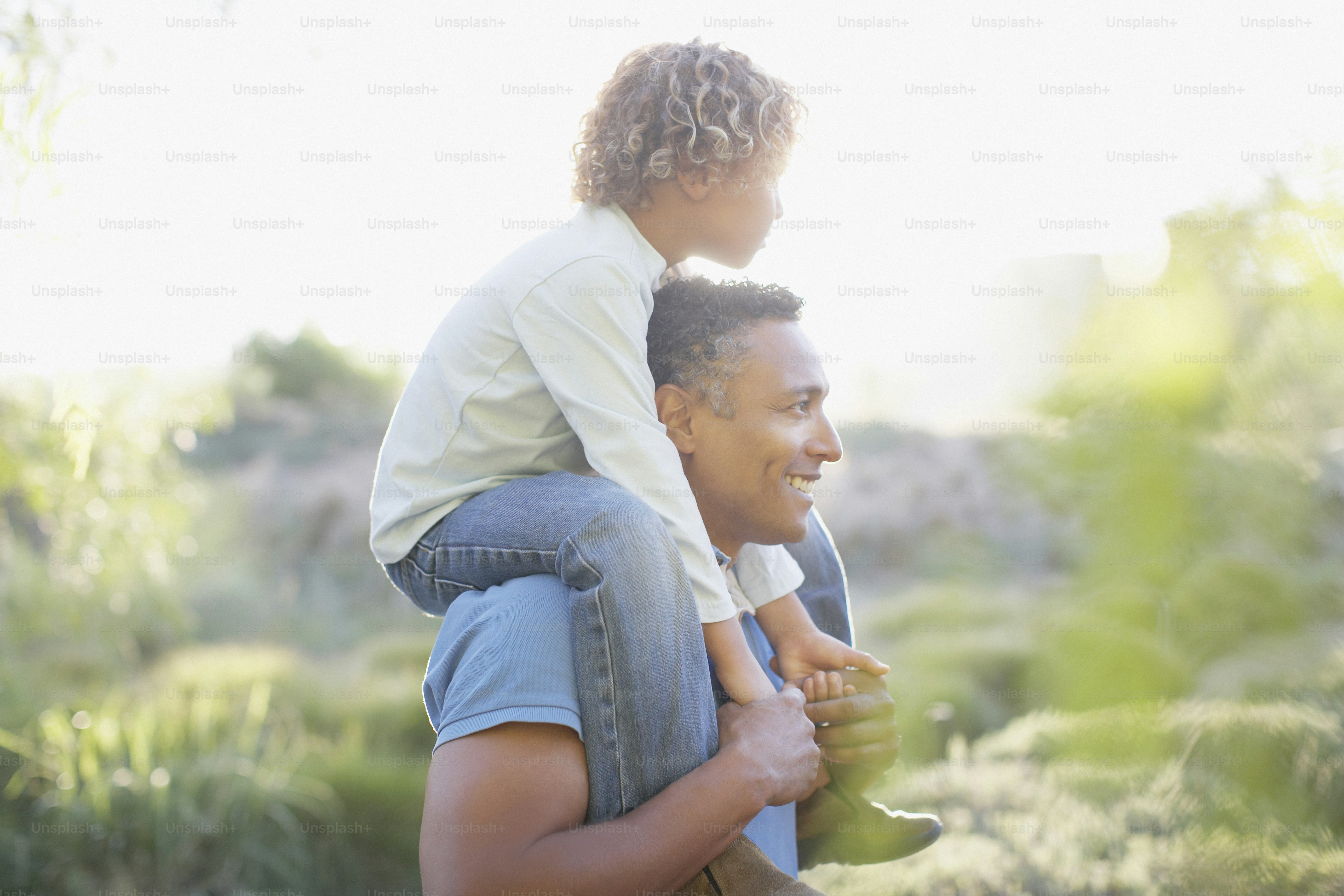 A man carrying a child on his back photo – Copy space Image on Unsplash